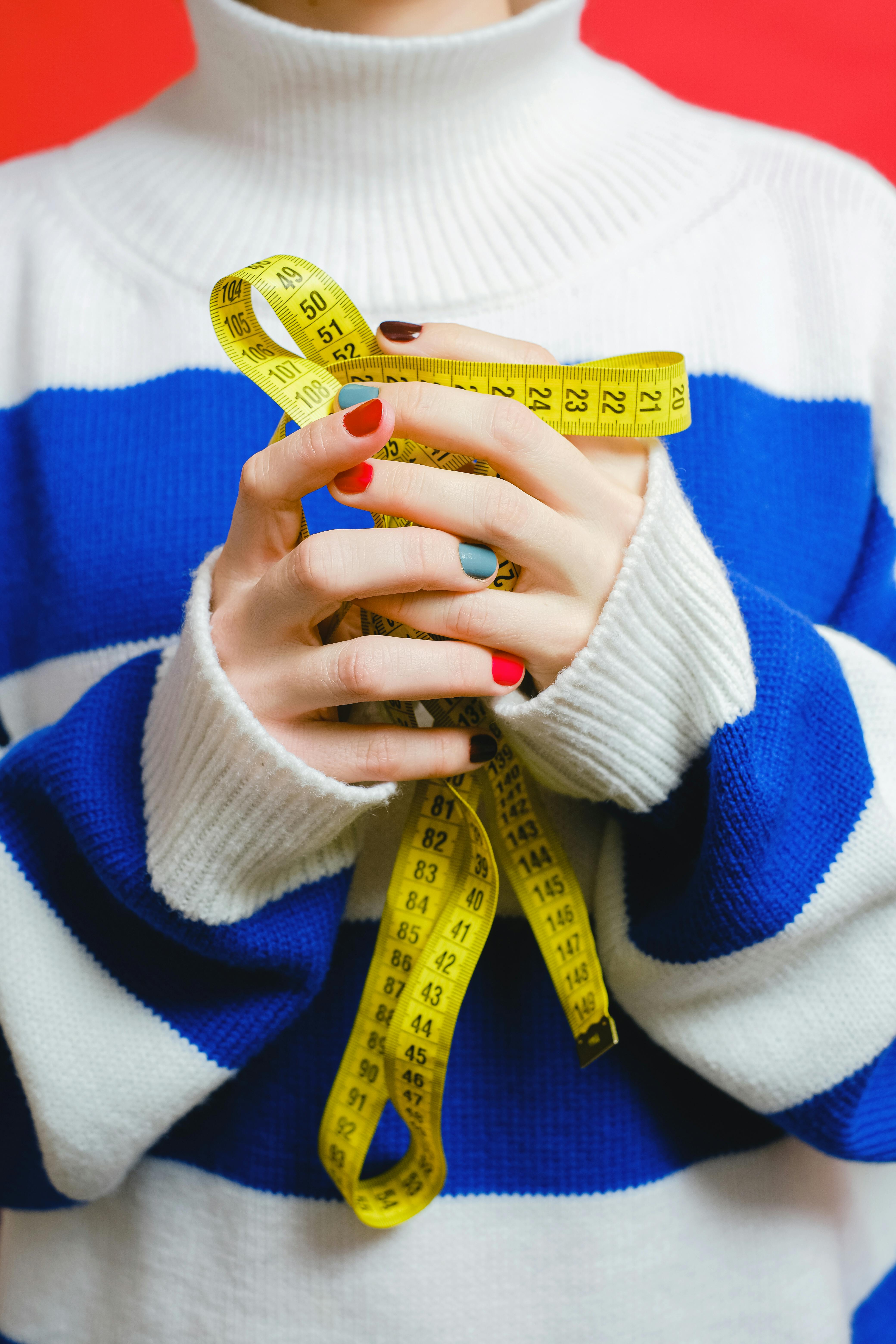 Person Holding a Tape Measure · Free Stock Photo