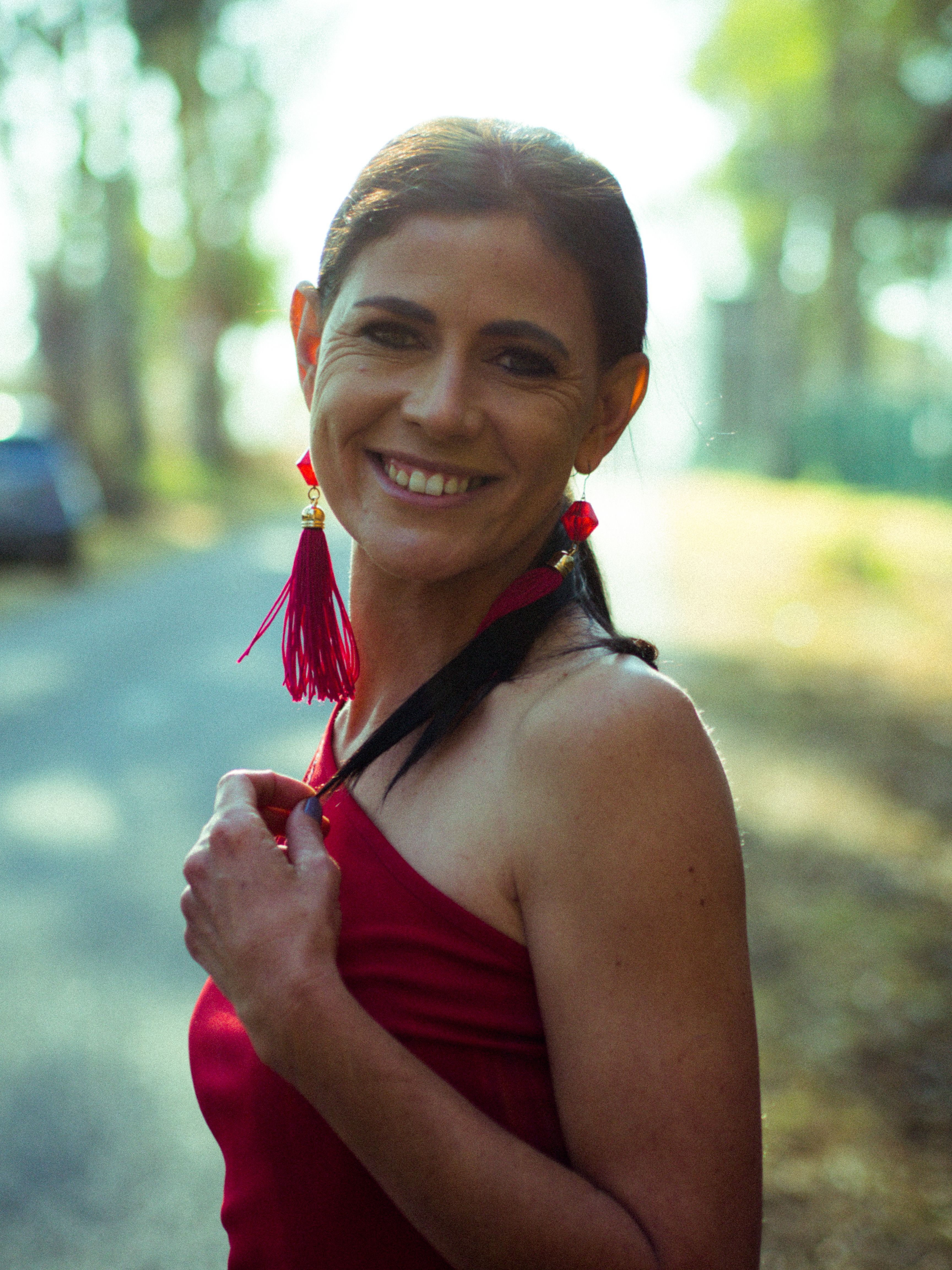 A Smiling Woman in Red Top and Dangling Earrings · Free Stock Photo