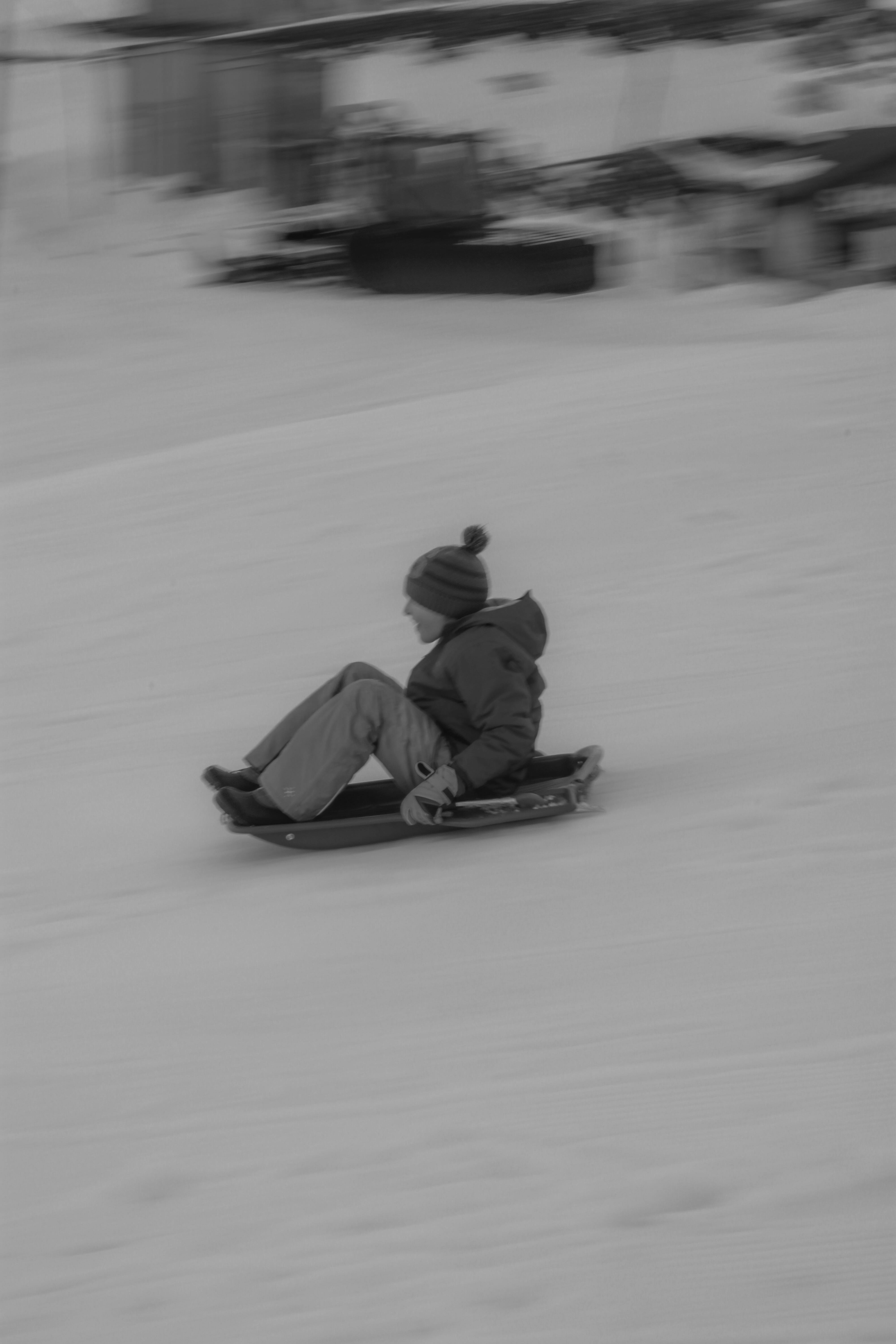 Grayscale Photo of a Boy Playing on Snow Field · Free Stock Photo