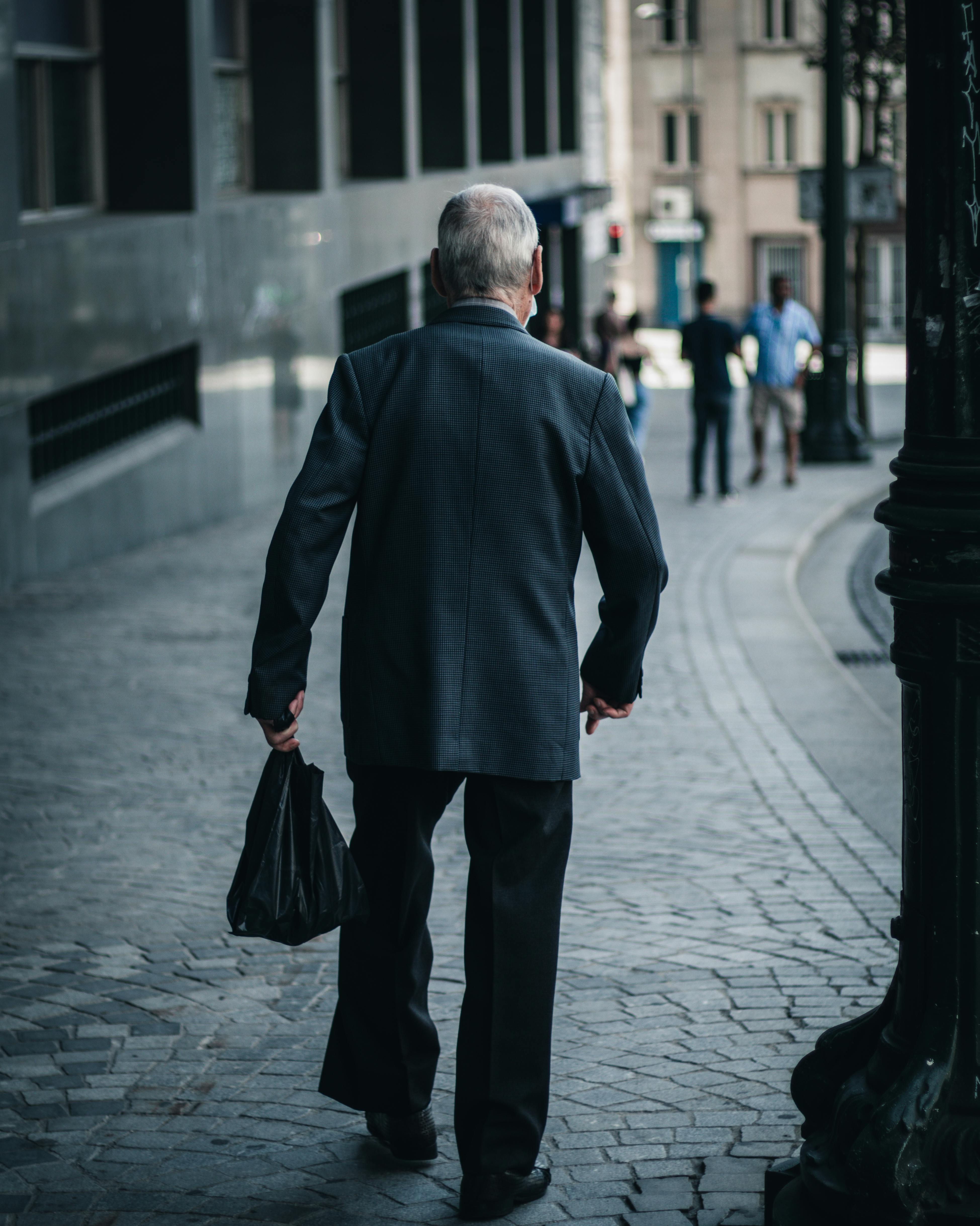Back View of a Man in Black Suit Walking on the Sidewalk · Free Stock Photo
