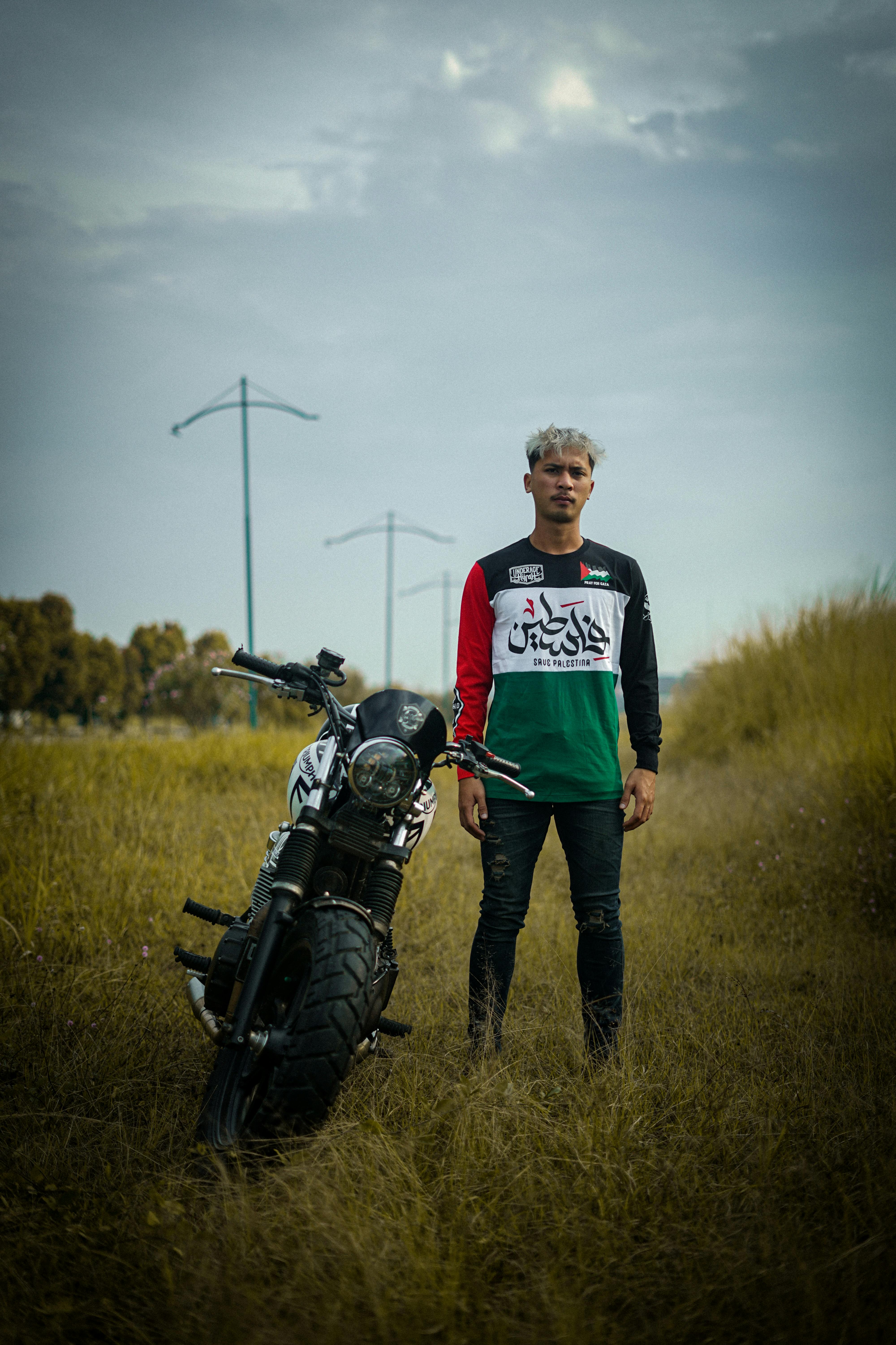 Man Standing near his Motorcycle Pointing on Back of his Shirt · Free ...