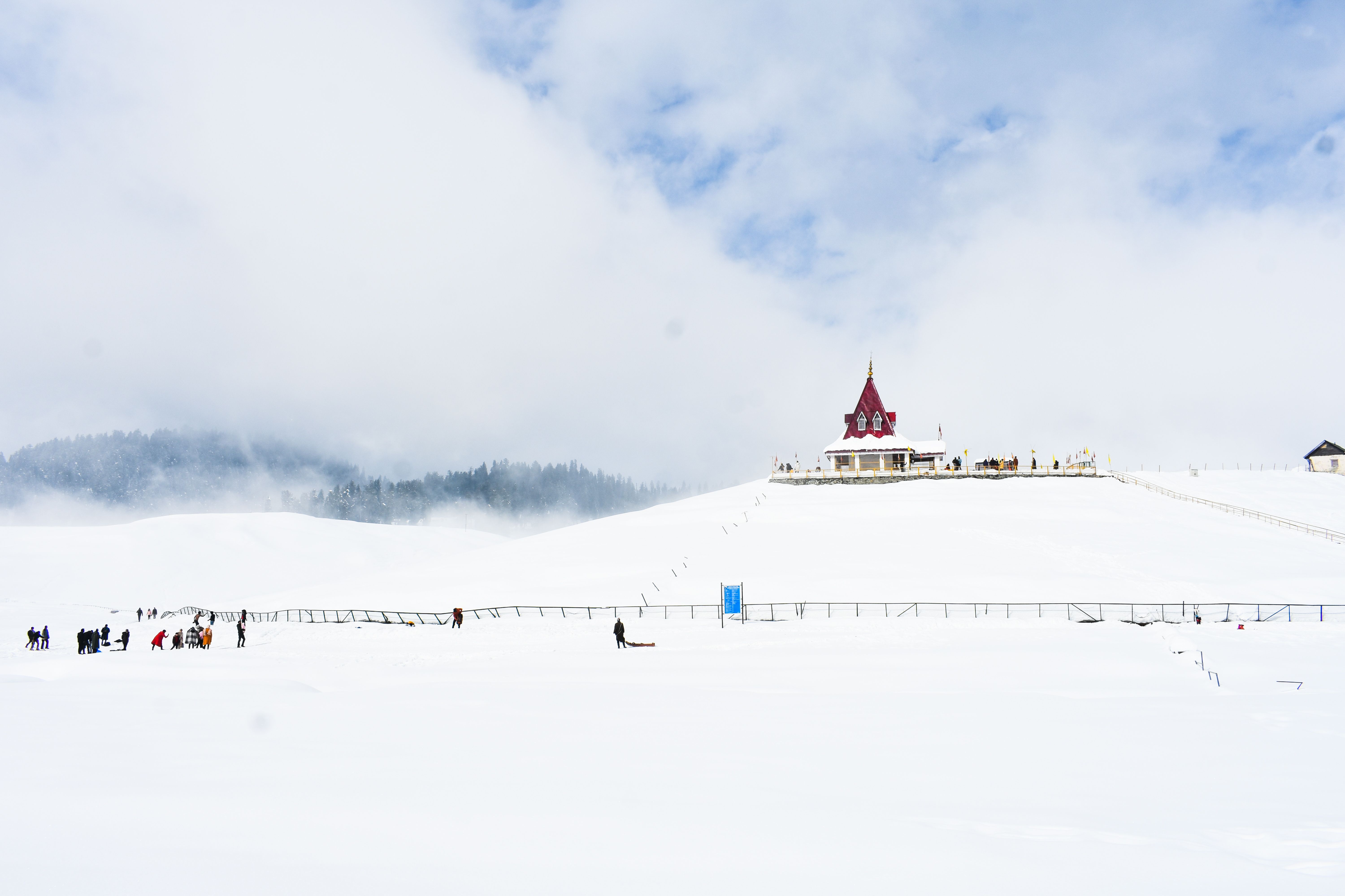 People on Snow near Hill with Building · Free Stock Photo
