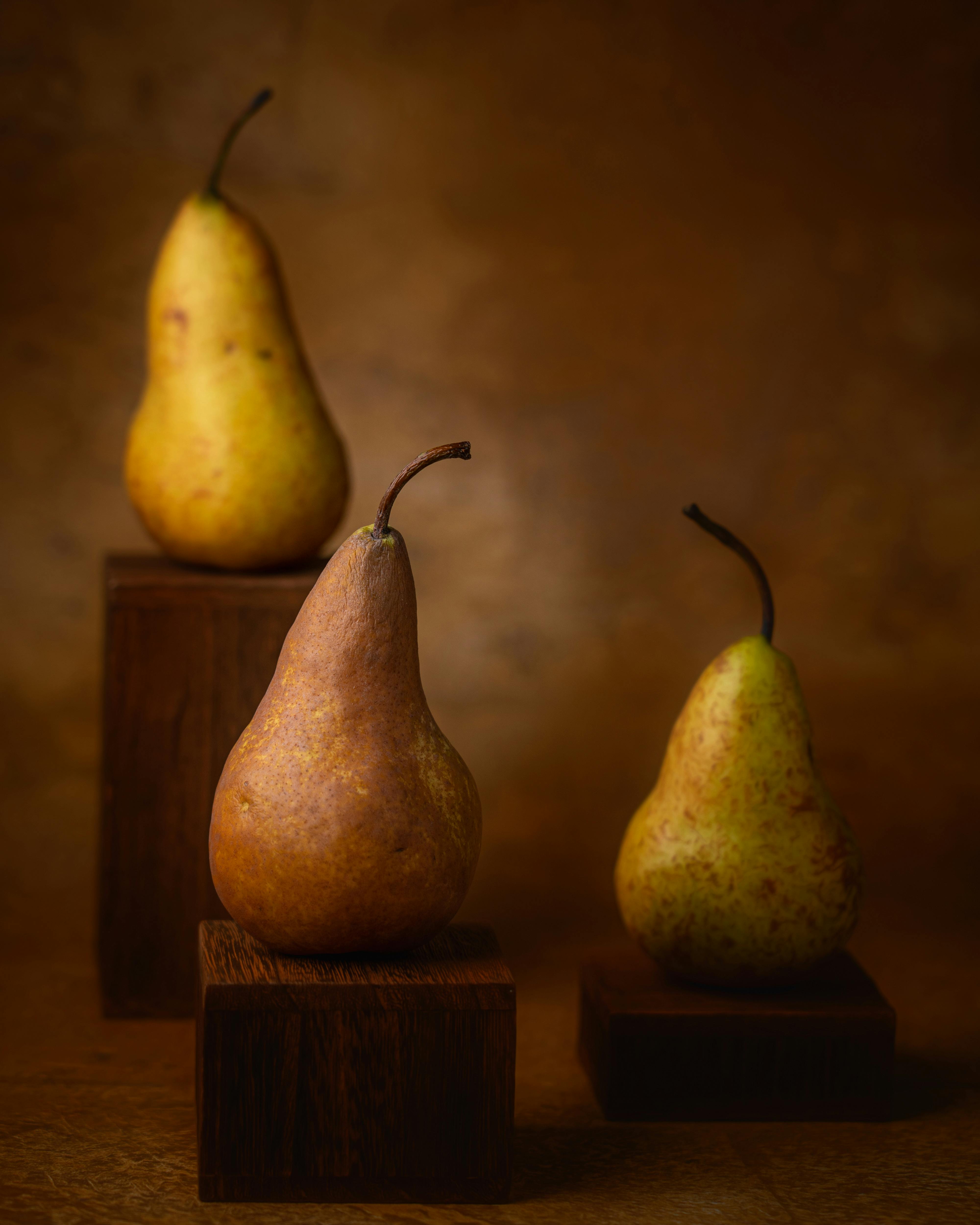 Green and Brown Pear Fruits on Brown Wooden Stands · Free Stock Photo