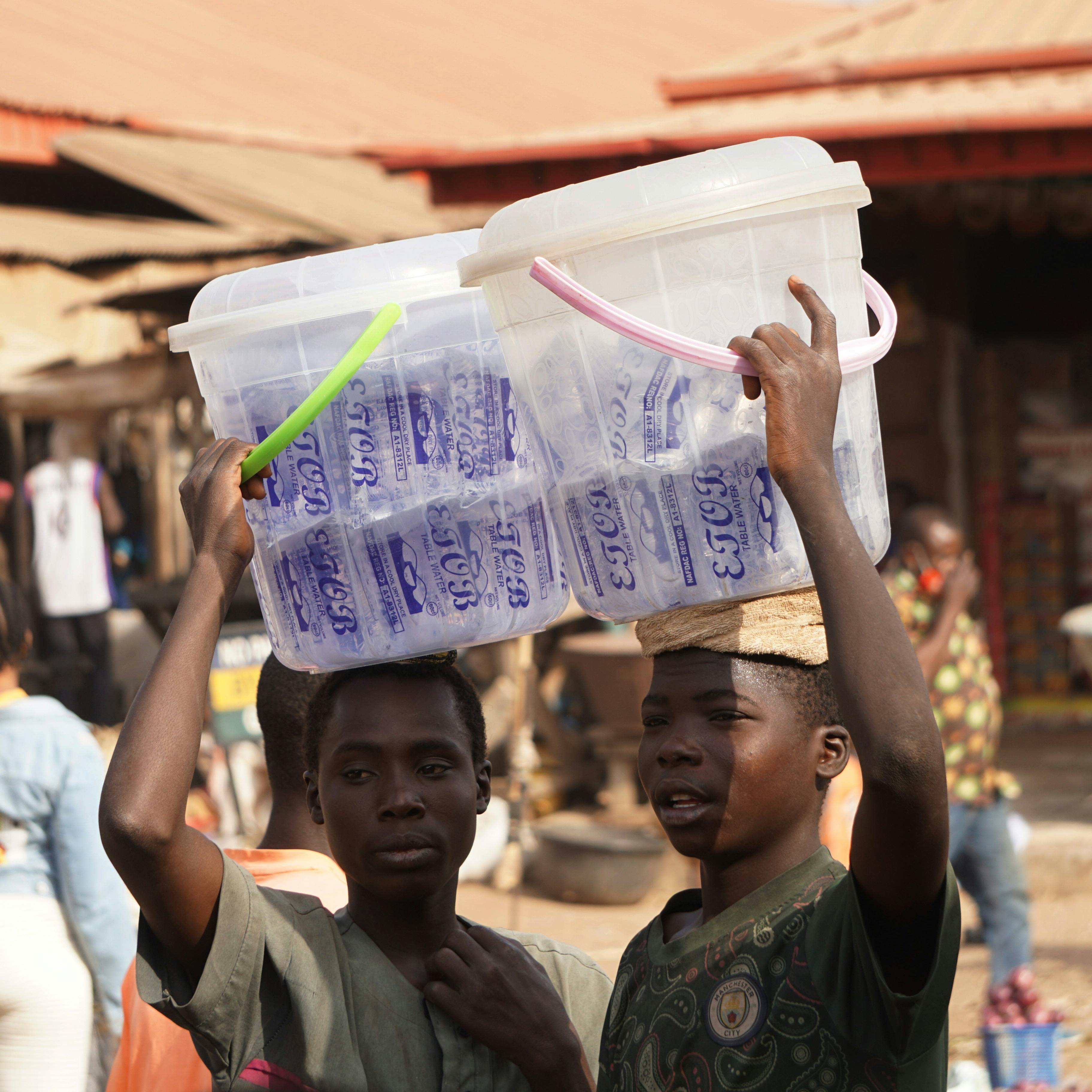 Boy in T-Shirt Carrying Bucket on Hand · Free Stock Photo