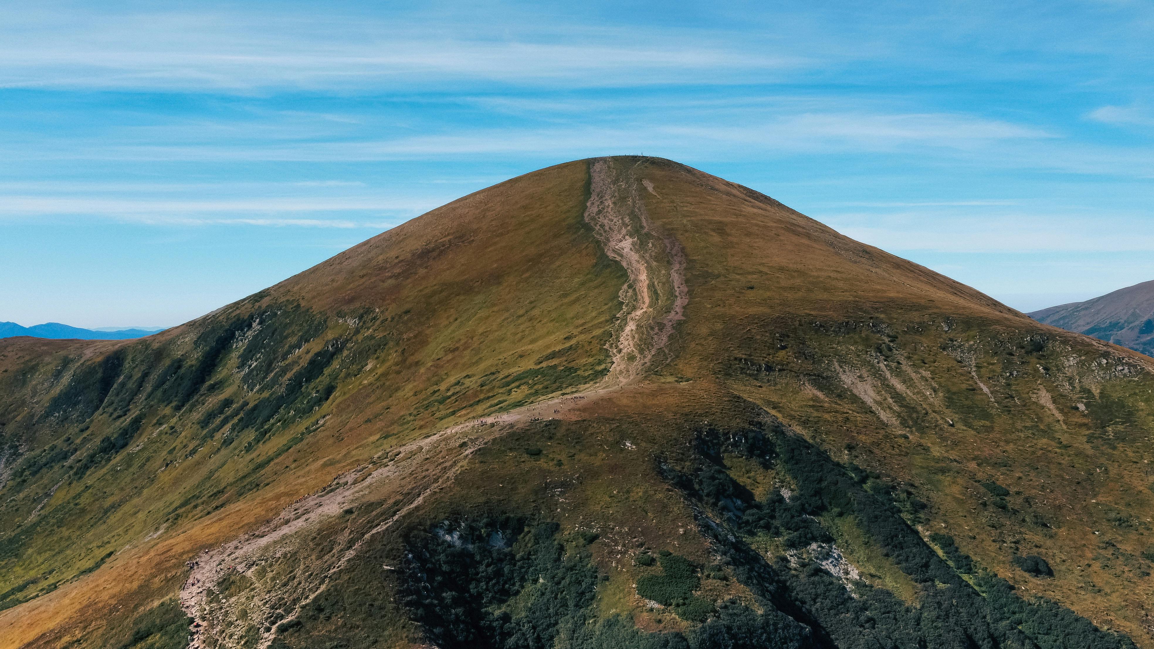 Bird Flying over Town in Valley among Hills · Free Stock Photo