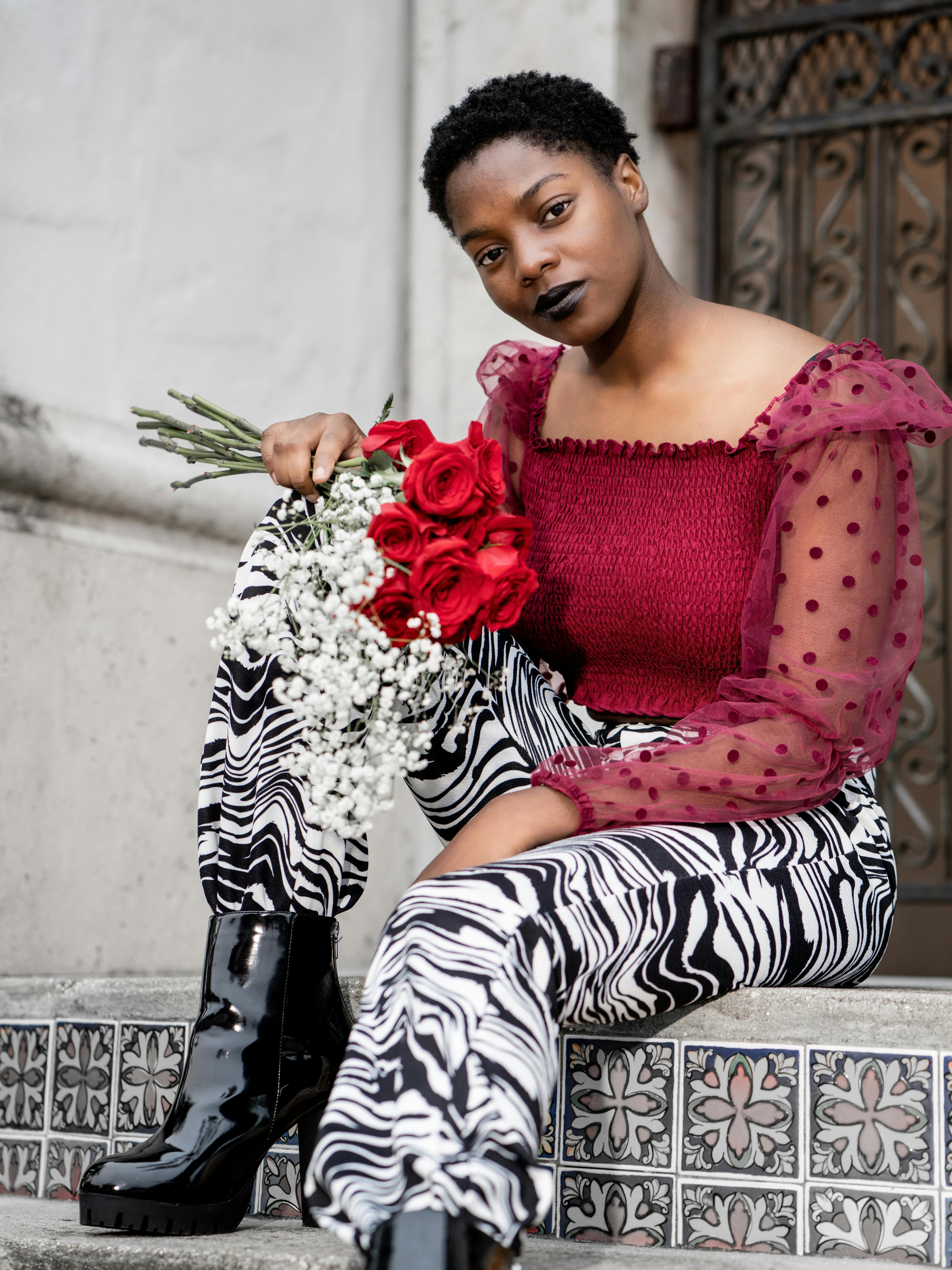 Woman Sitting on Step While Holding Flowers · Free Stock Photo