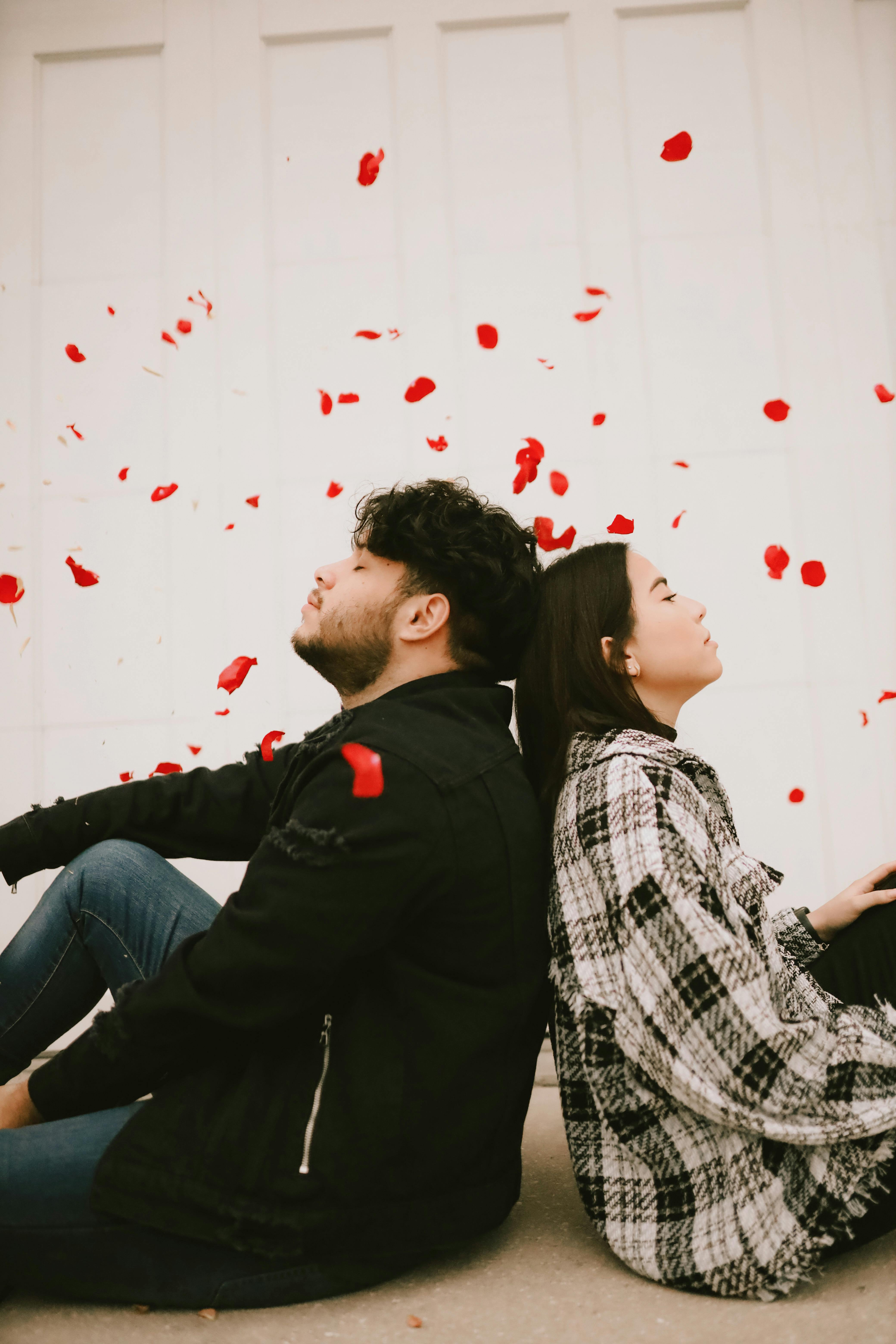 A Couple Sitting Back to Back · Free Stock Photo