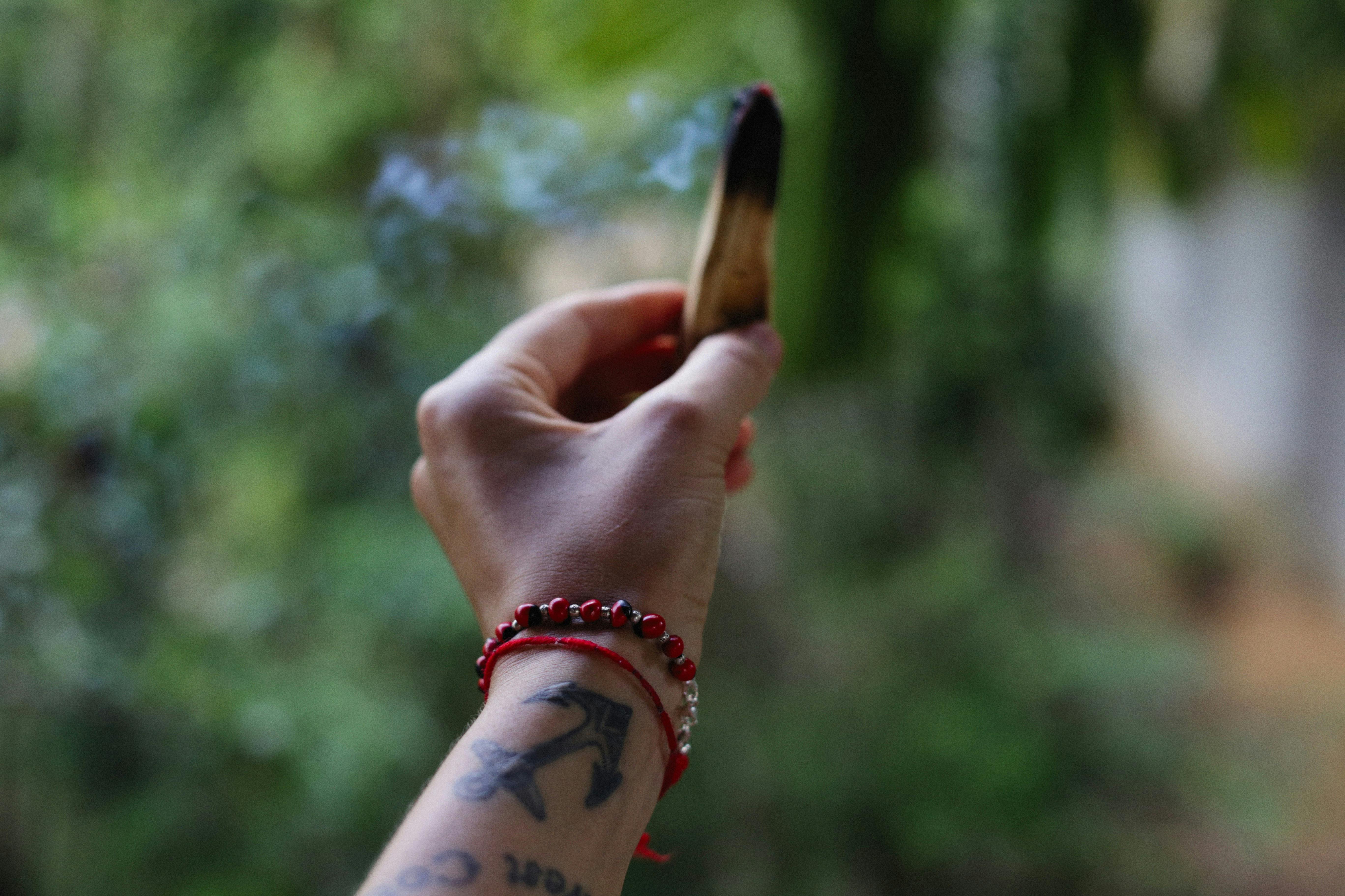 A Hand Holding a Burning Palo Santo · Free Stock Photo