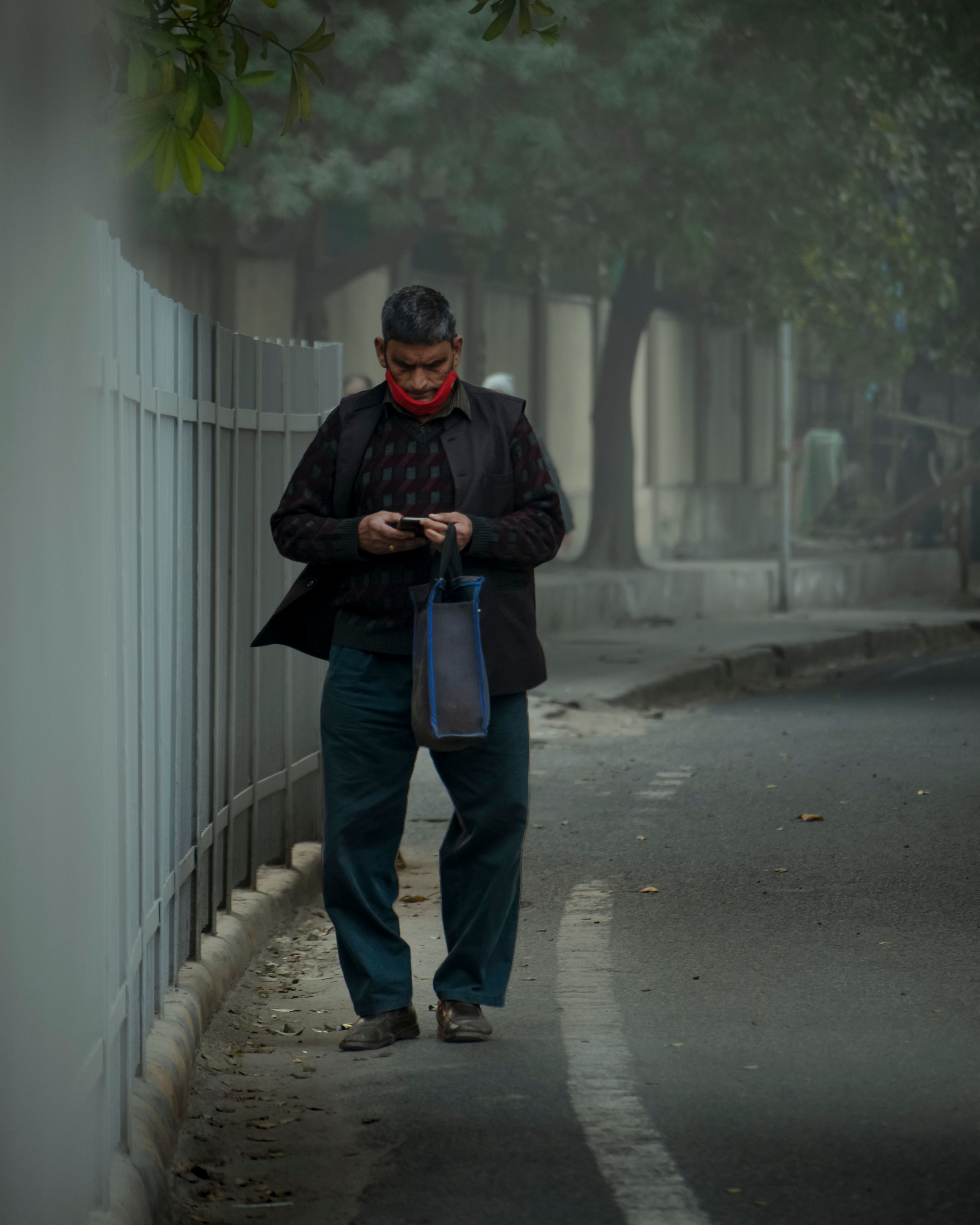 A Man Wearing Face Mask Walking on the Side of the Street while Busy ...