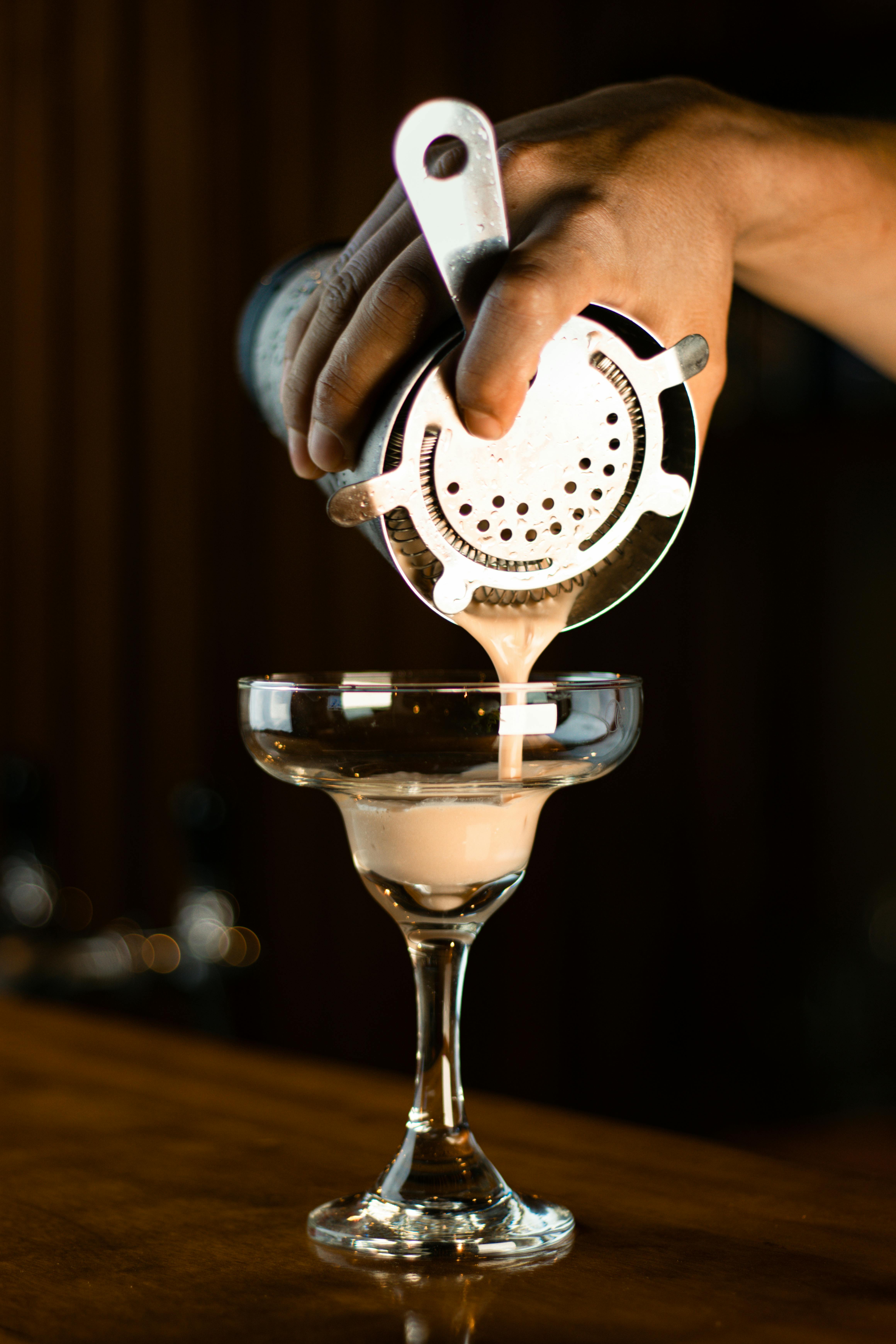 Person Pouring Cocktail Drink on Clear Glass · Free Stock Photo