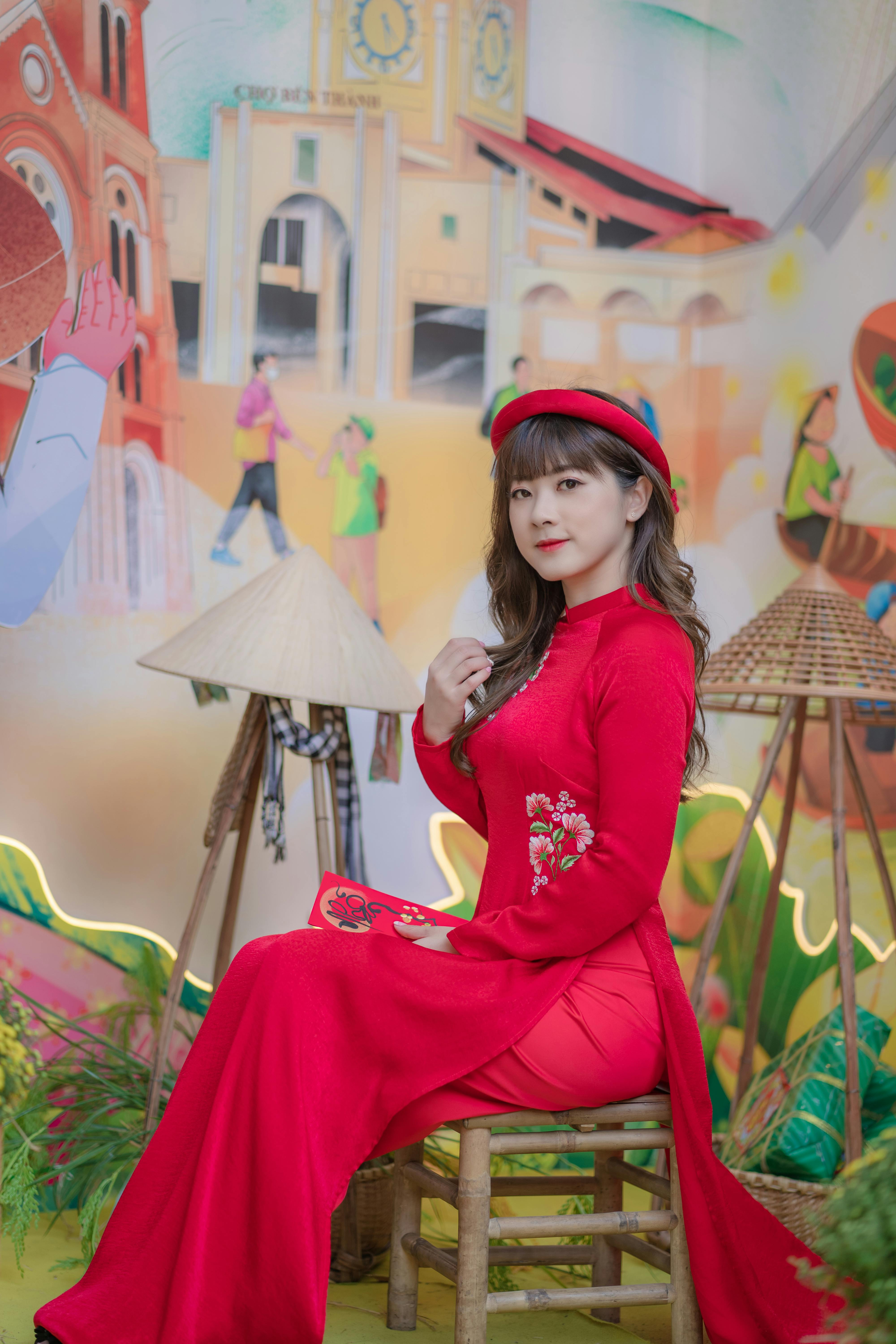 Woman in Orange Dress Leaning on Concrete Railing · Free Stock Photo