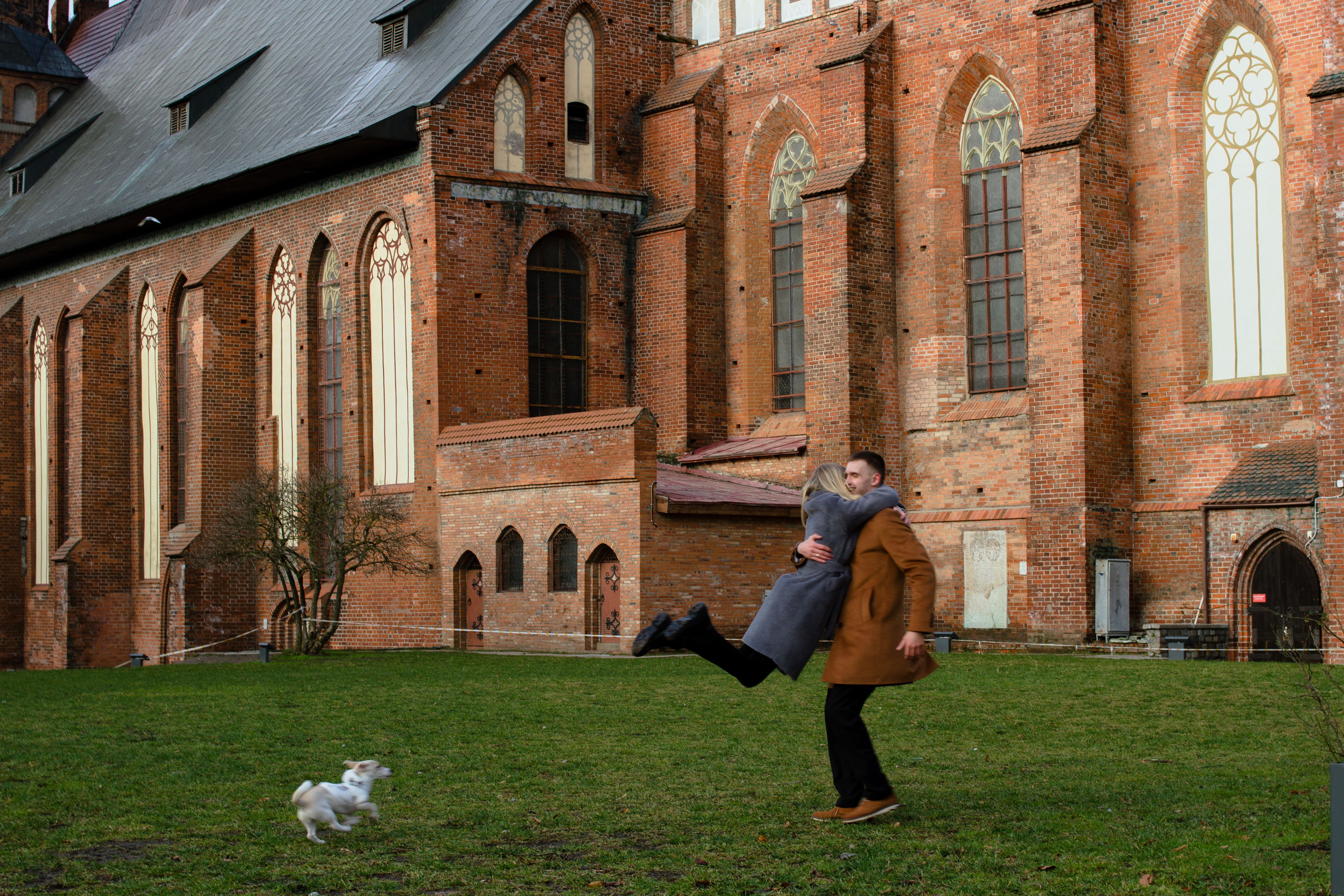 Couple Walking Dog by Church · Free Stock Photo