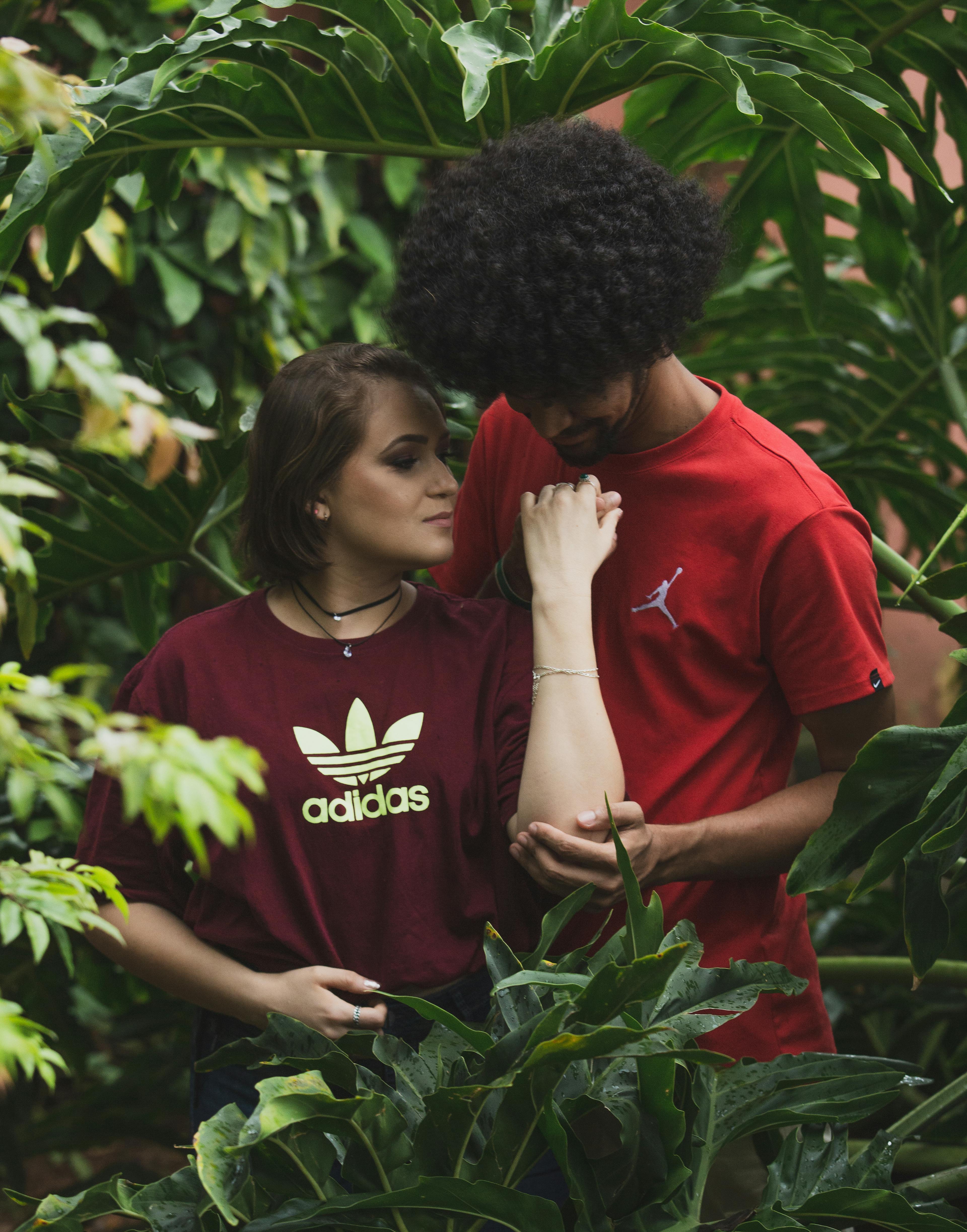A Man and a Woman Standing Near a Wall with Vine Plants · Free Stock Photo