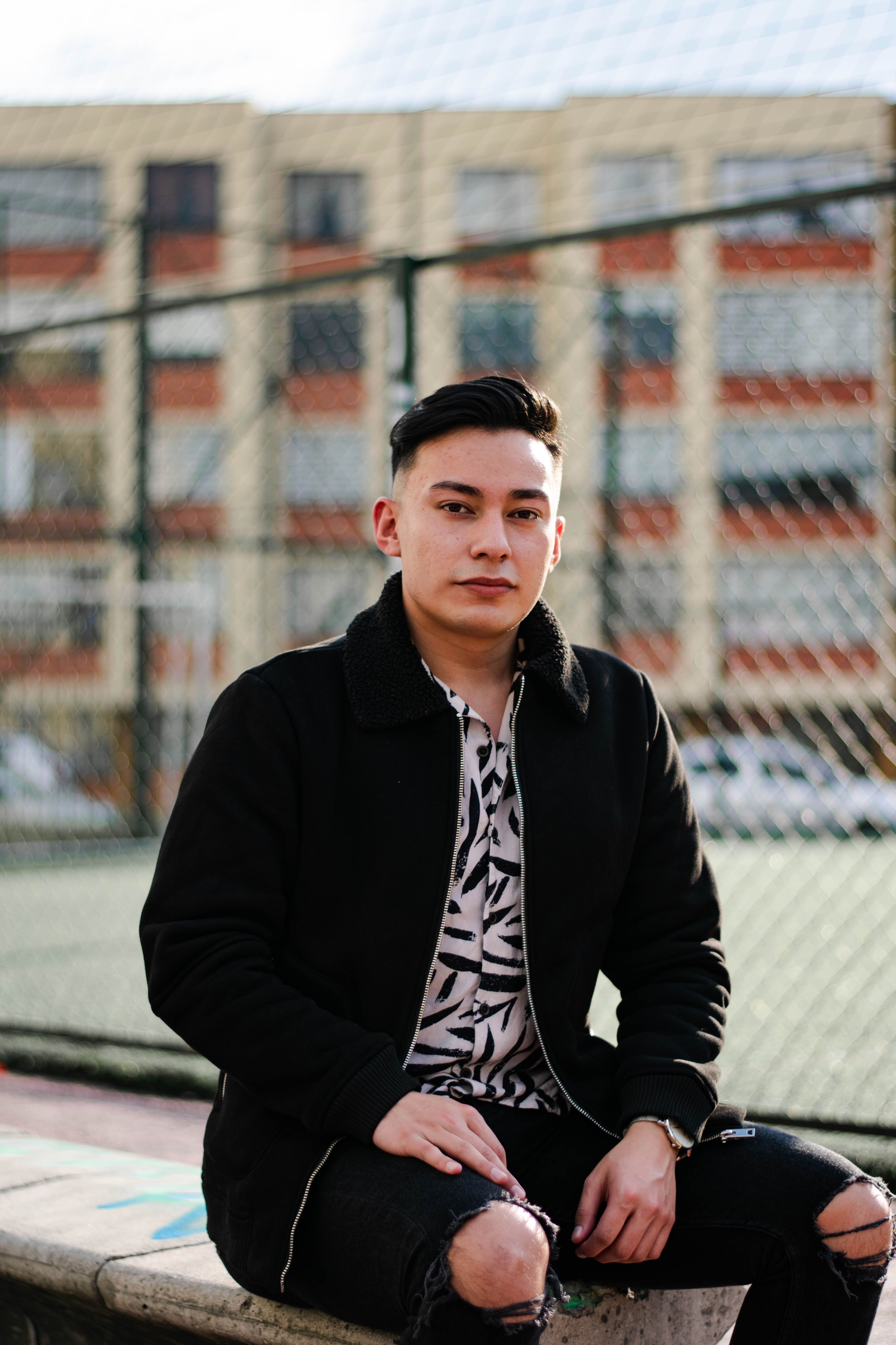 Young Man Sitting in Black Jacket · Free Stock Photo