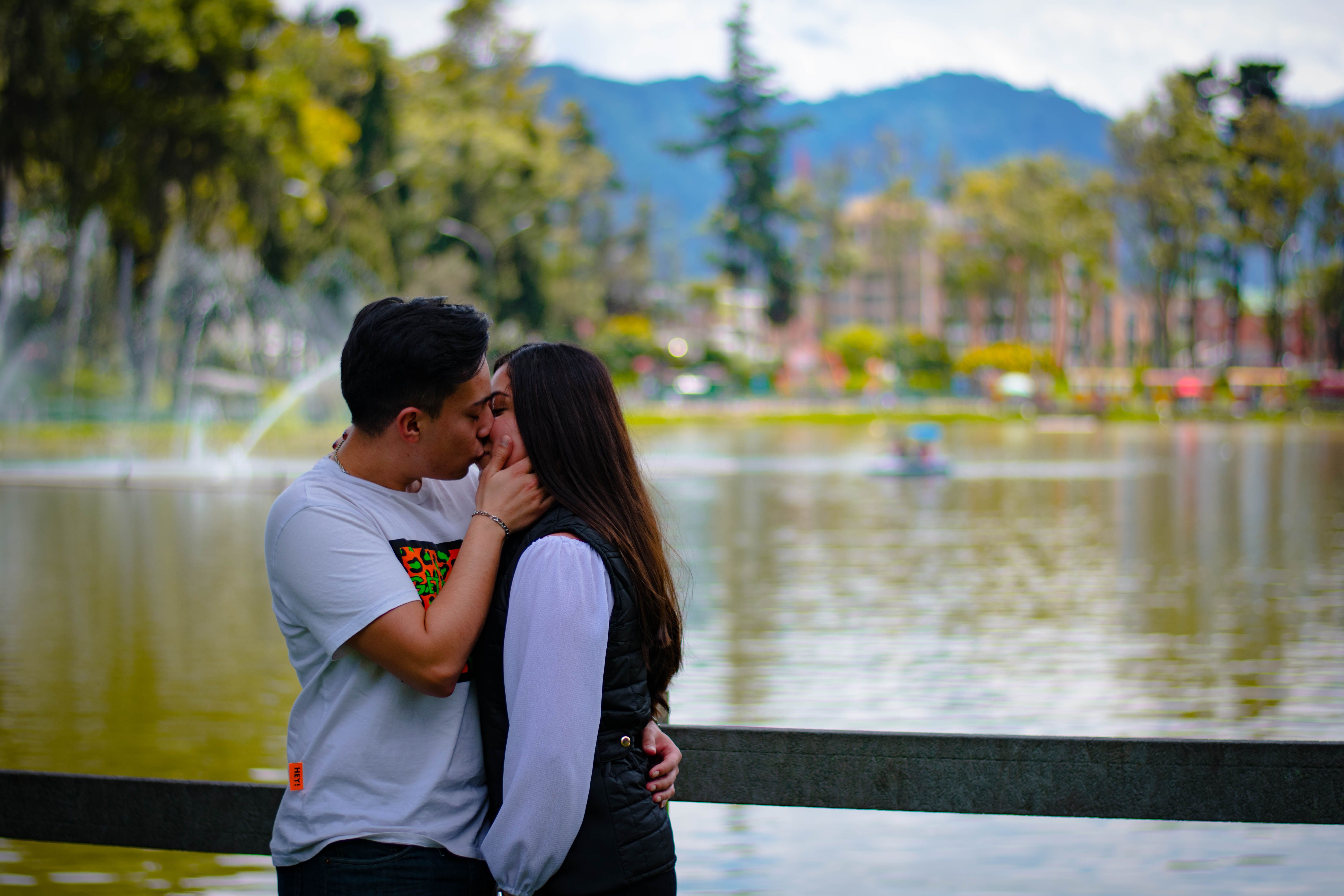 A Man and a Woman Kissing Near Body of Water · Free Stock Photo