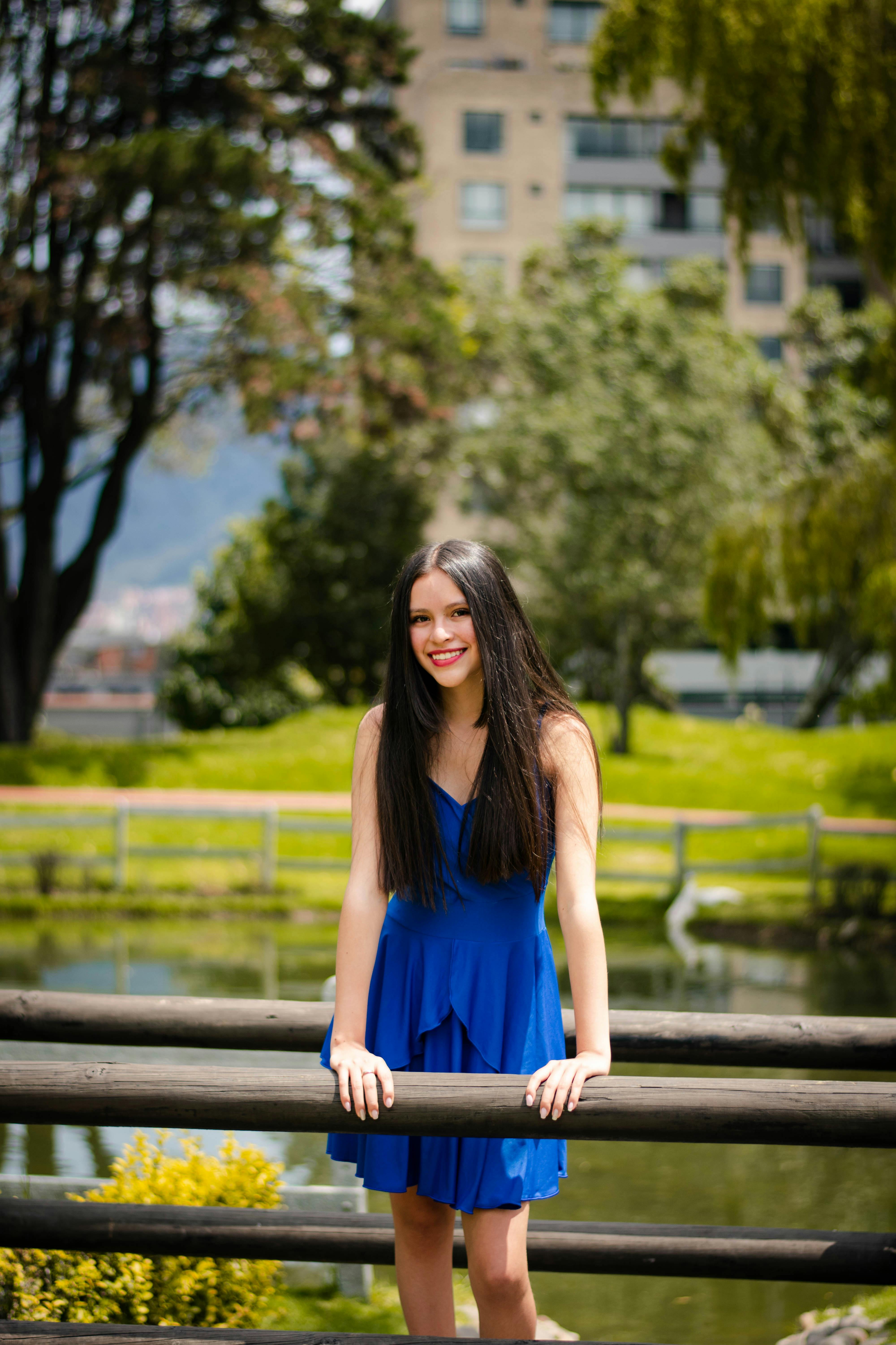 A Woman in Blue Dress Standing on Bridge · Free Stock Photo