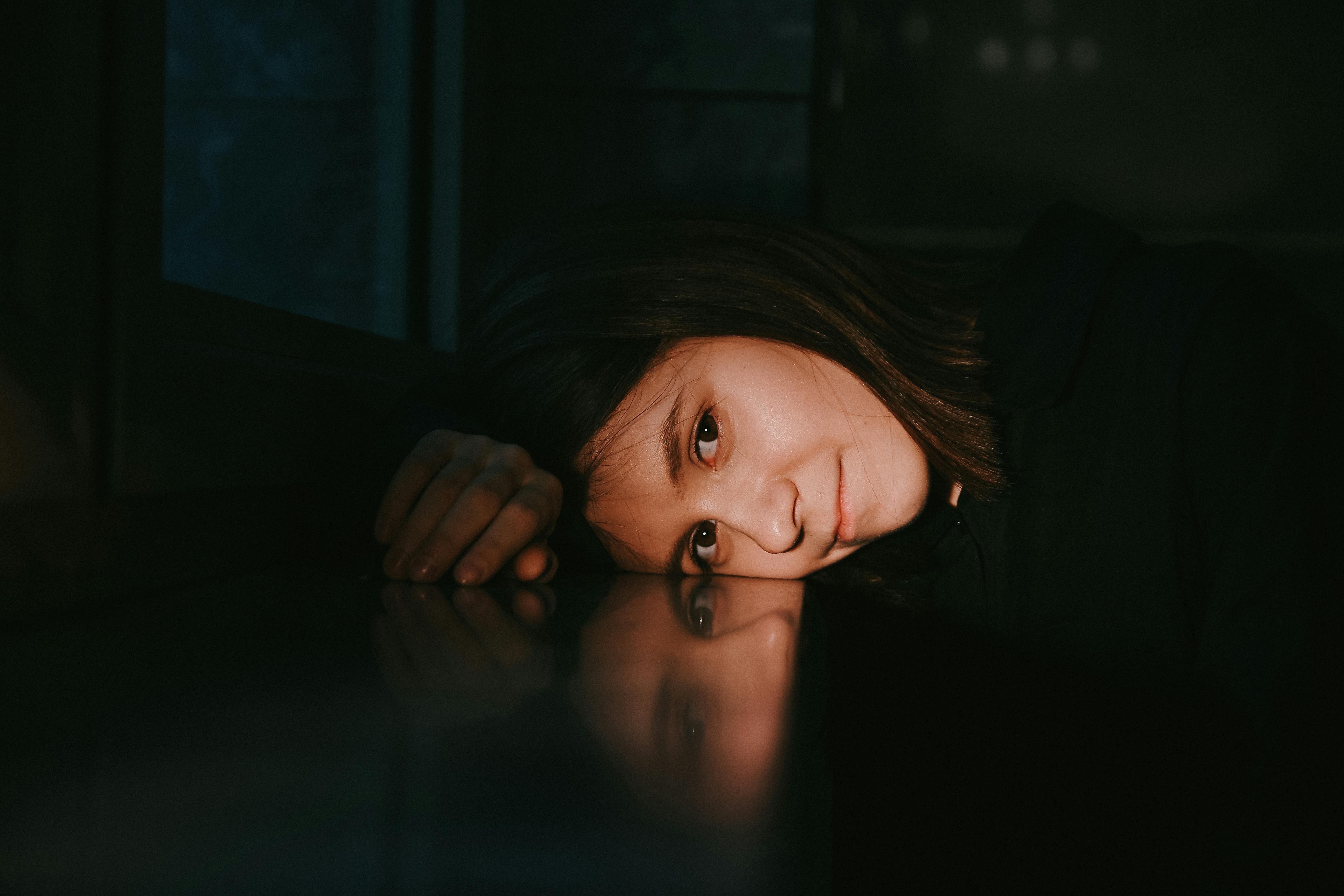 Girl Lying on Table in Dark · Free Stock Photo