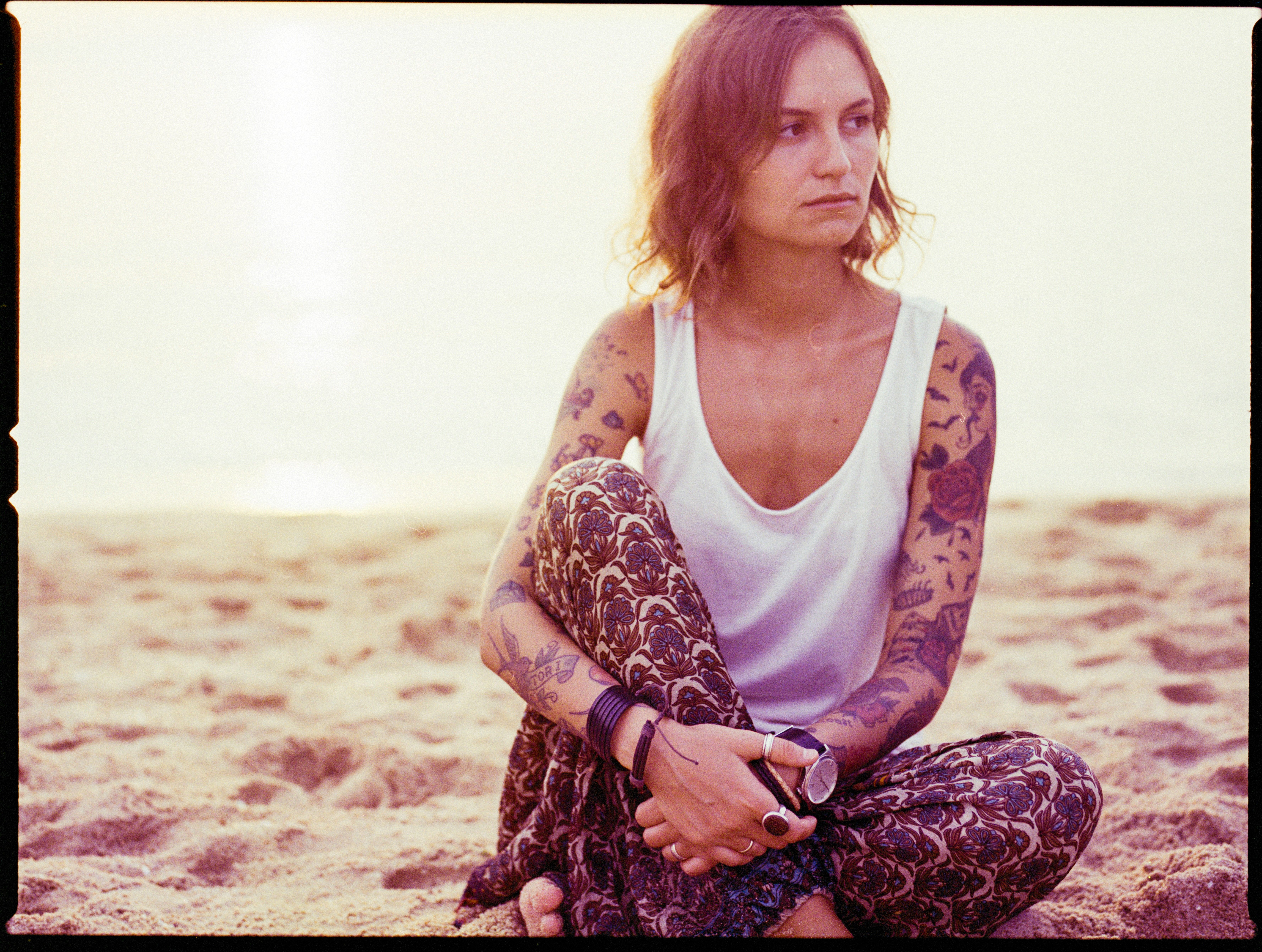 Woman with Tattoos Sitting on the Sand · Free Stock Photo