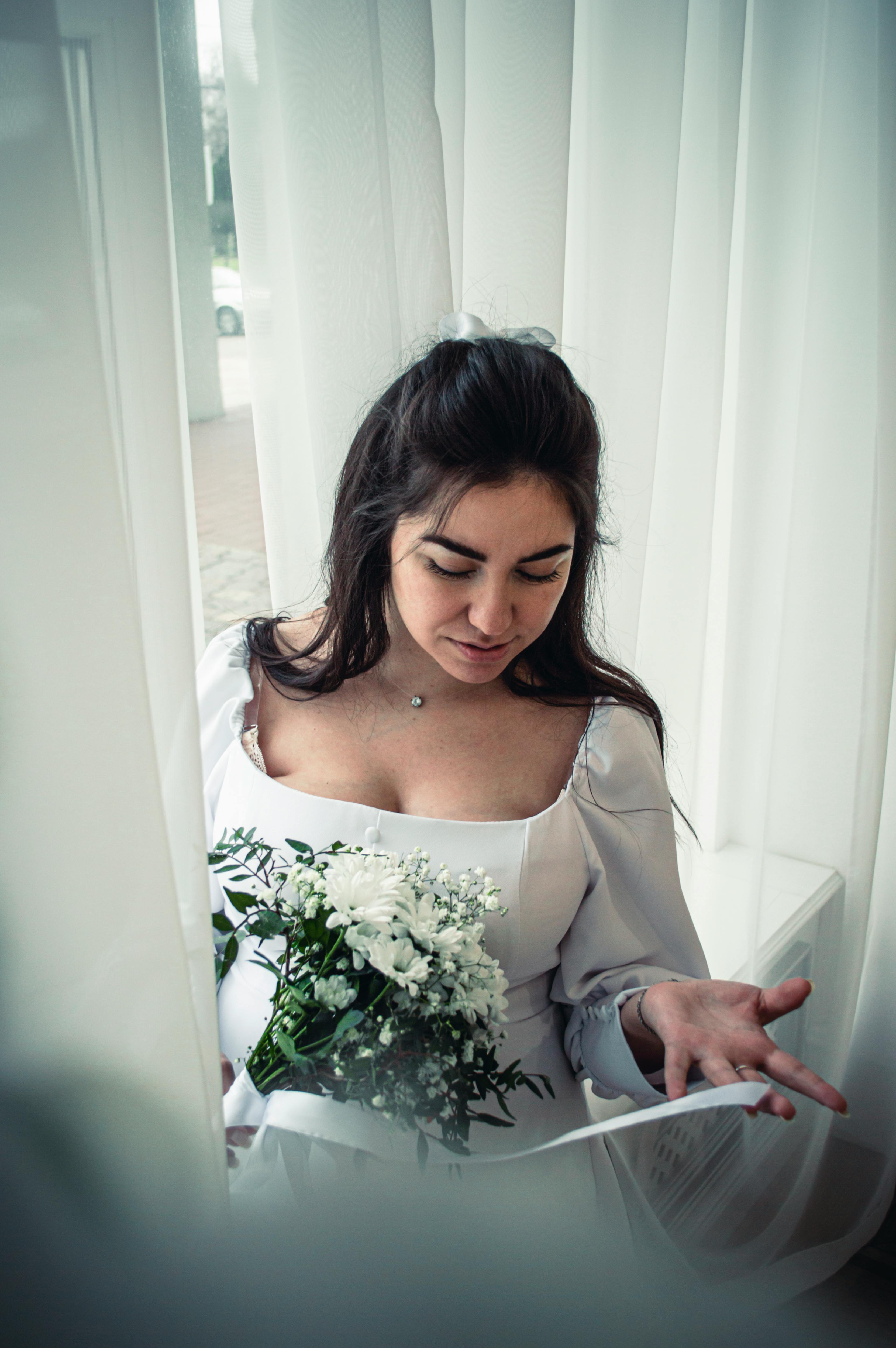 Portrait of woman in wedding dress with bouquet · Free Stock Photo