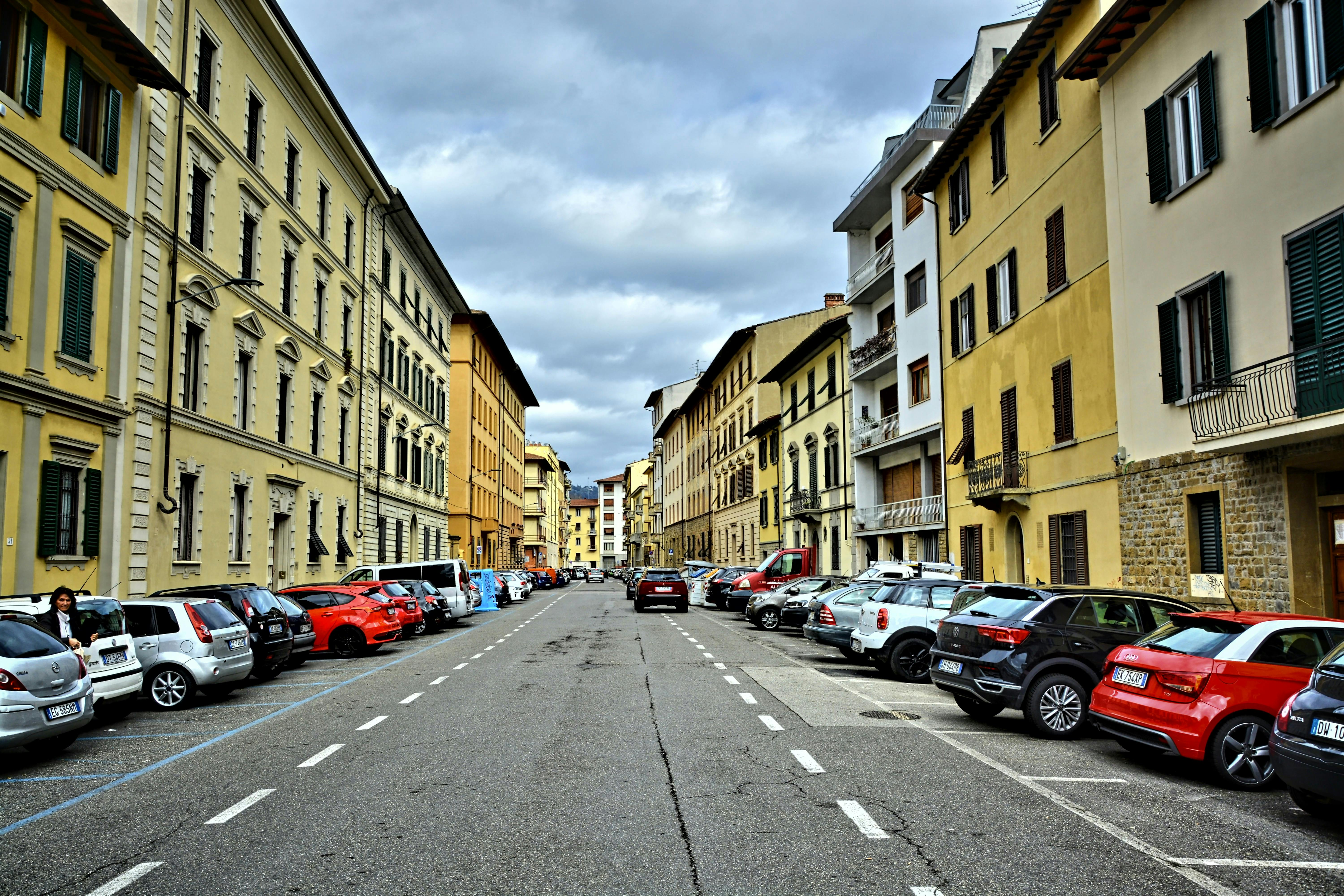 Cars Parked on the Side of the Road in Between Buildings · Free Stock Photo