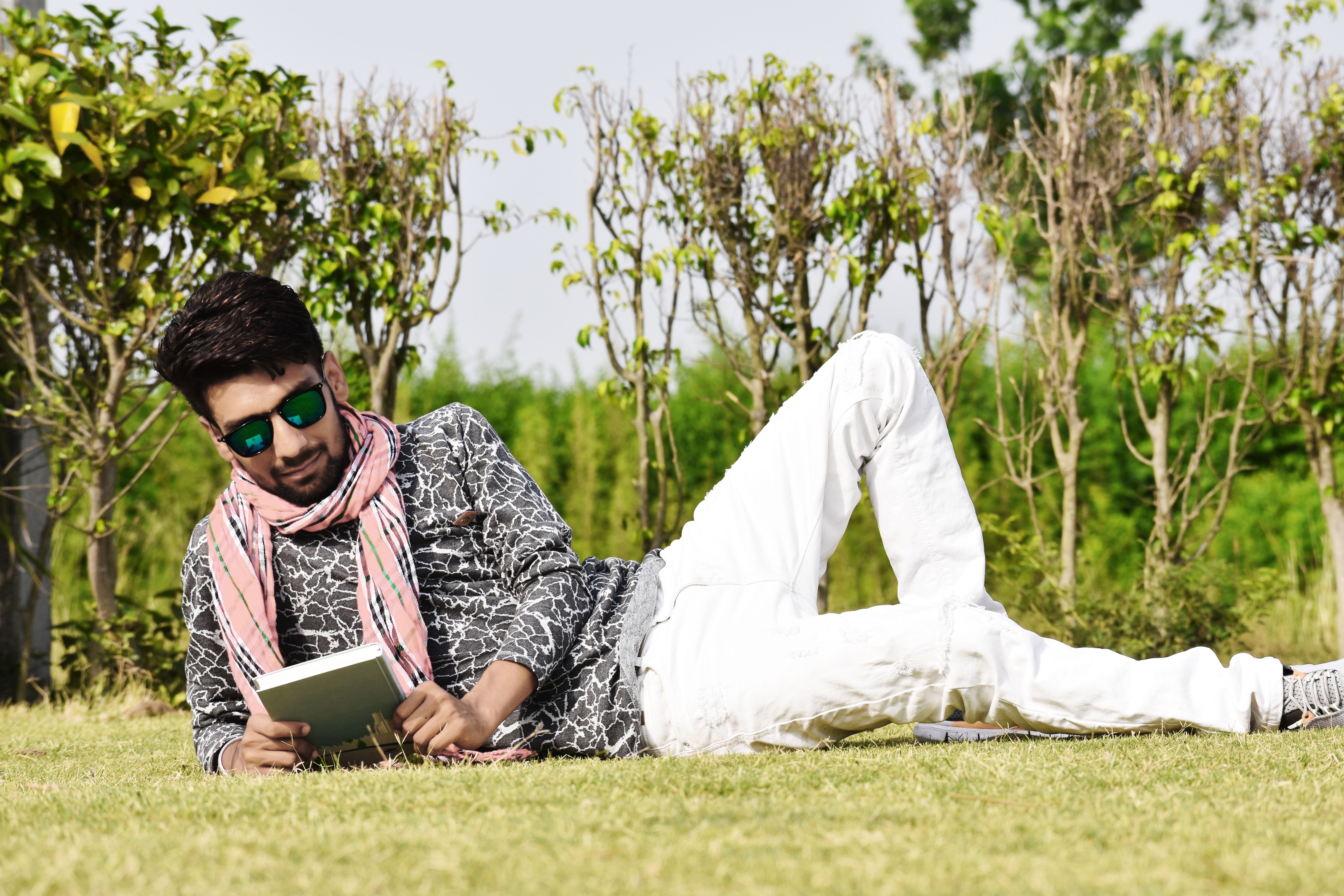 Man in White Pants Wearing Sunglasses Reading Book · Free Stock Photo