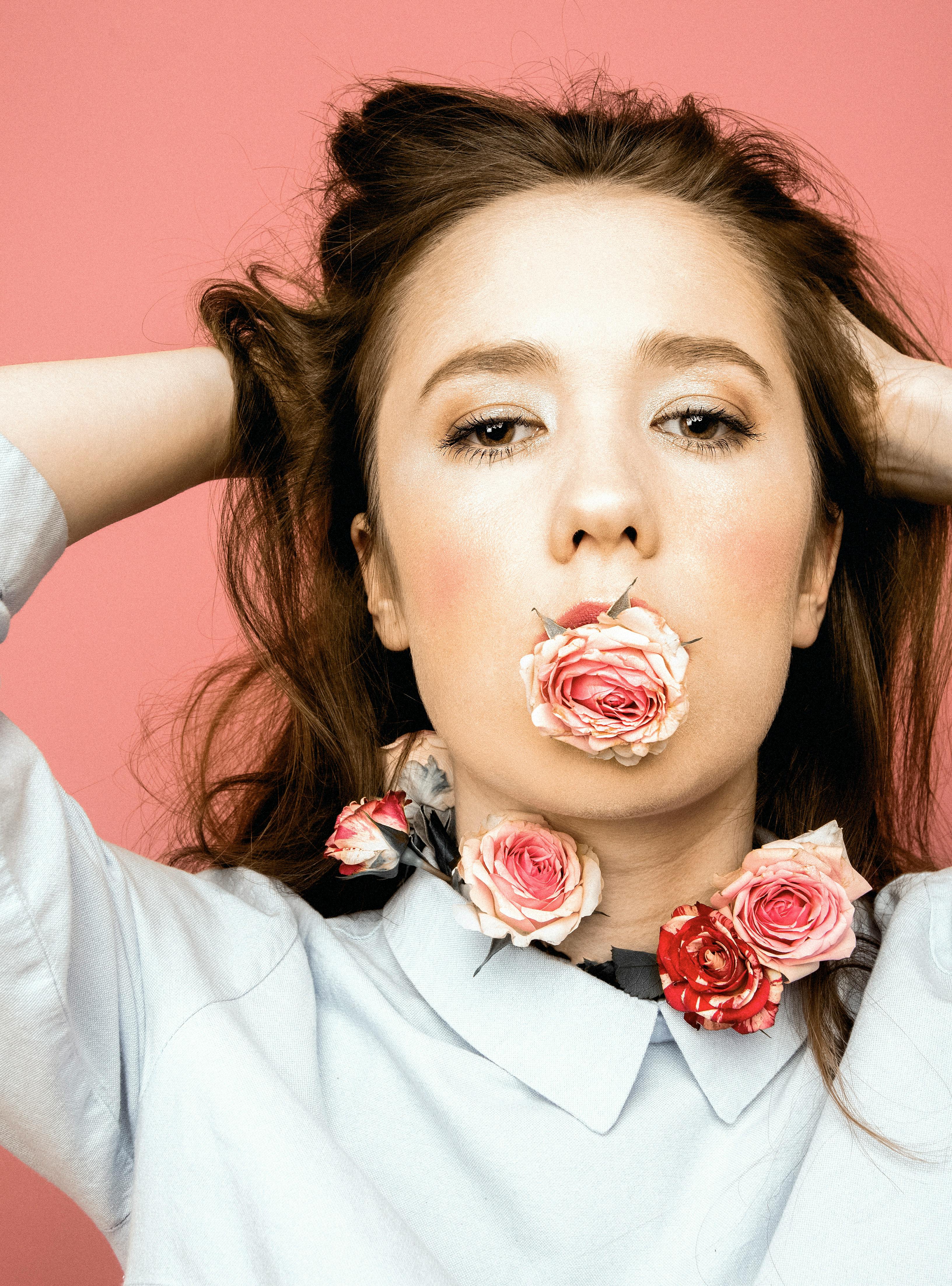 A Woman in a Pink Dress Biting a Rose · Free Stock Photo
