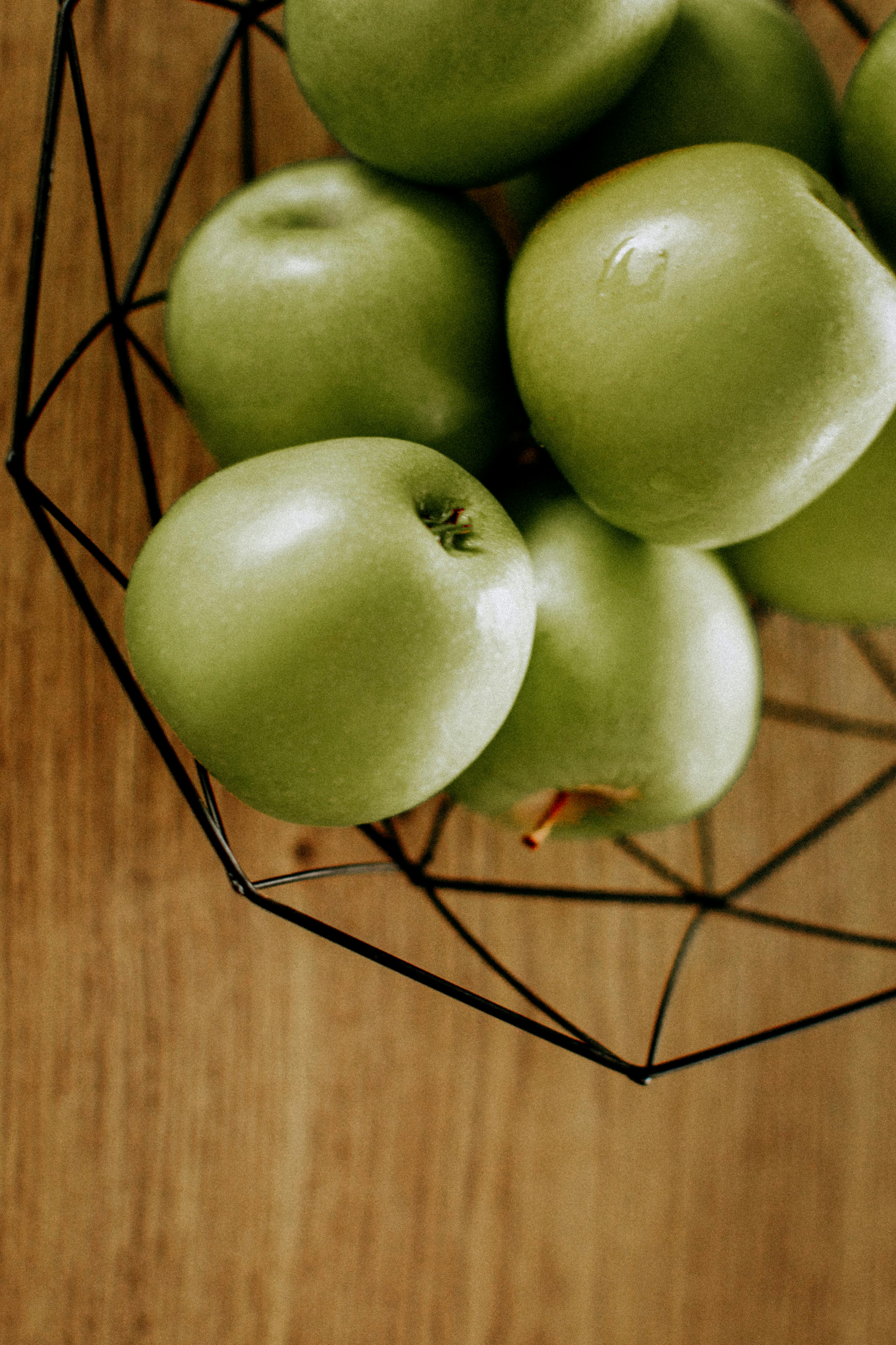 Green Apples in a Geometric Wire Bowl · Free Stock Photo