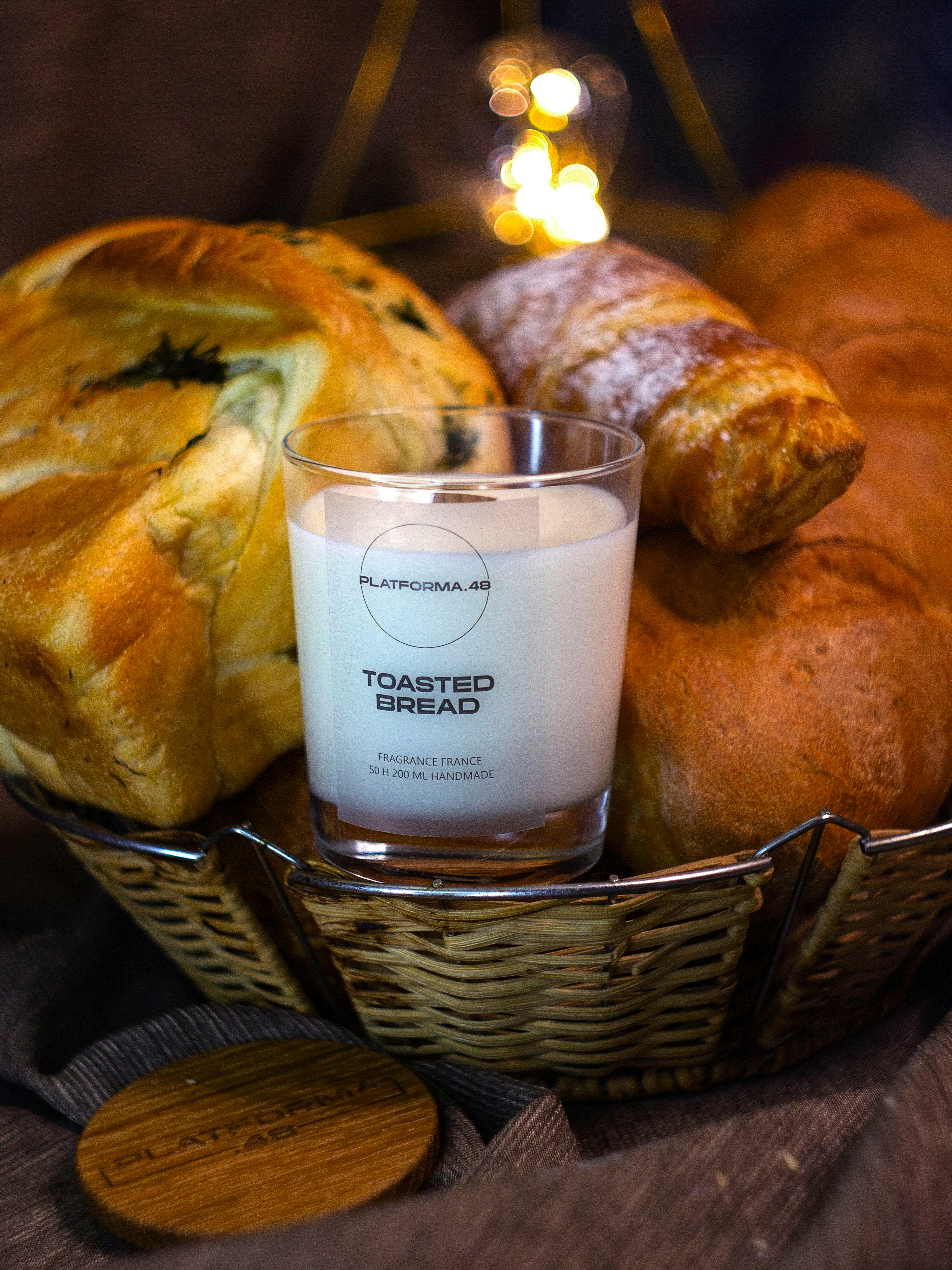 Close-Up Photo of a Scented Candle Near Bread · Free Stock Photo