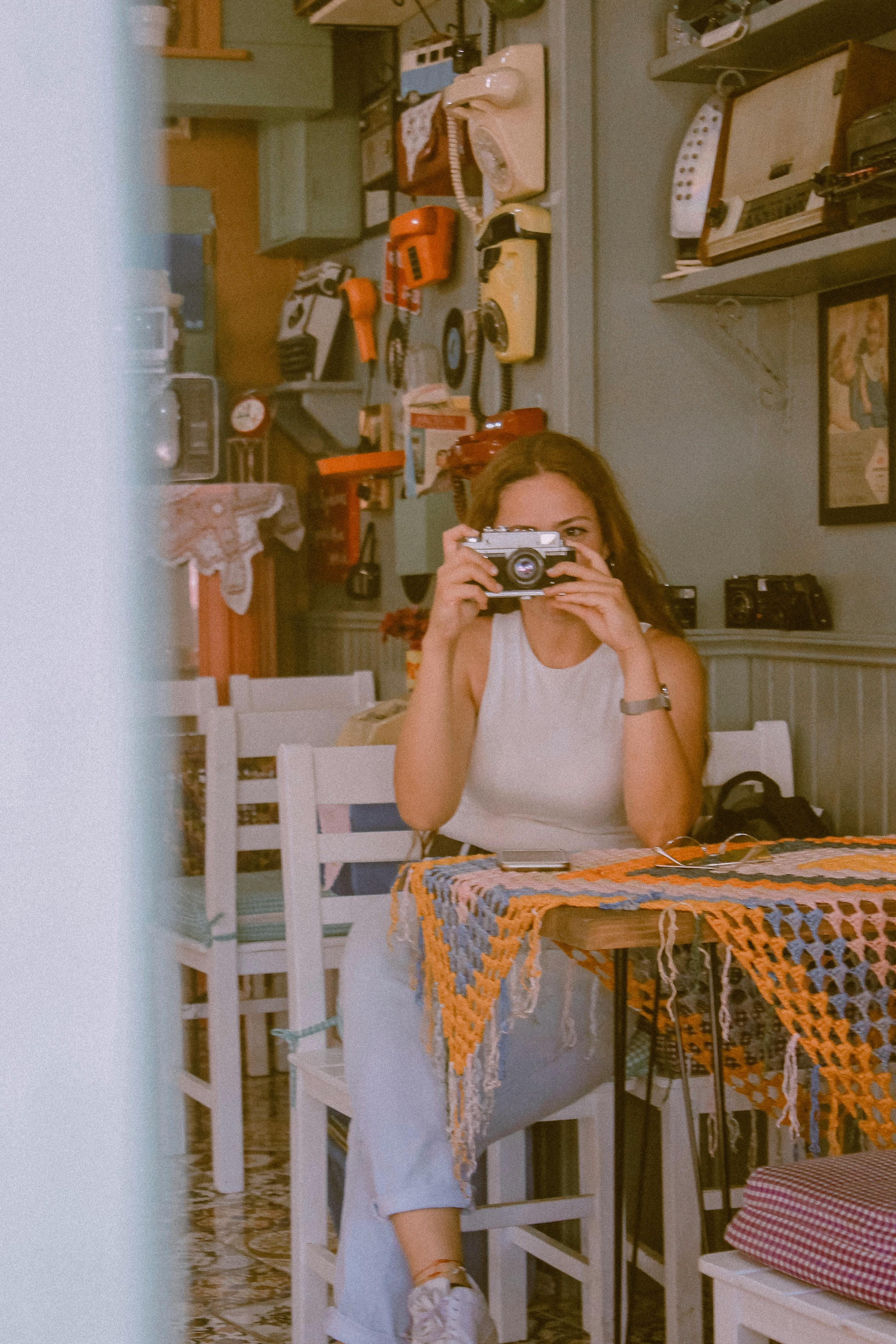 Woman Sitting by a Table and Taking a Photo with a Camera · Free Stock ...