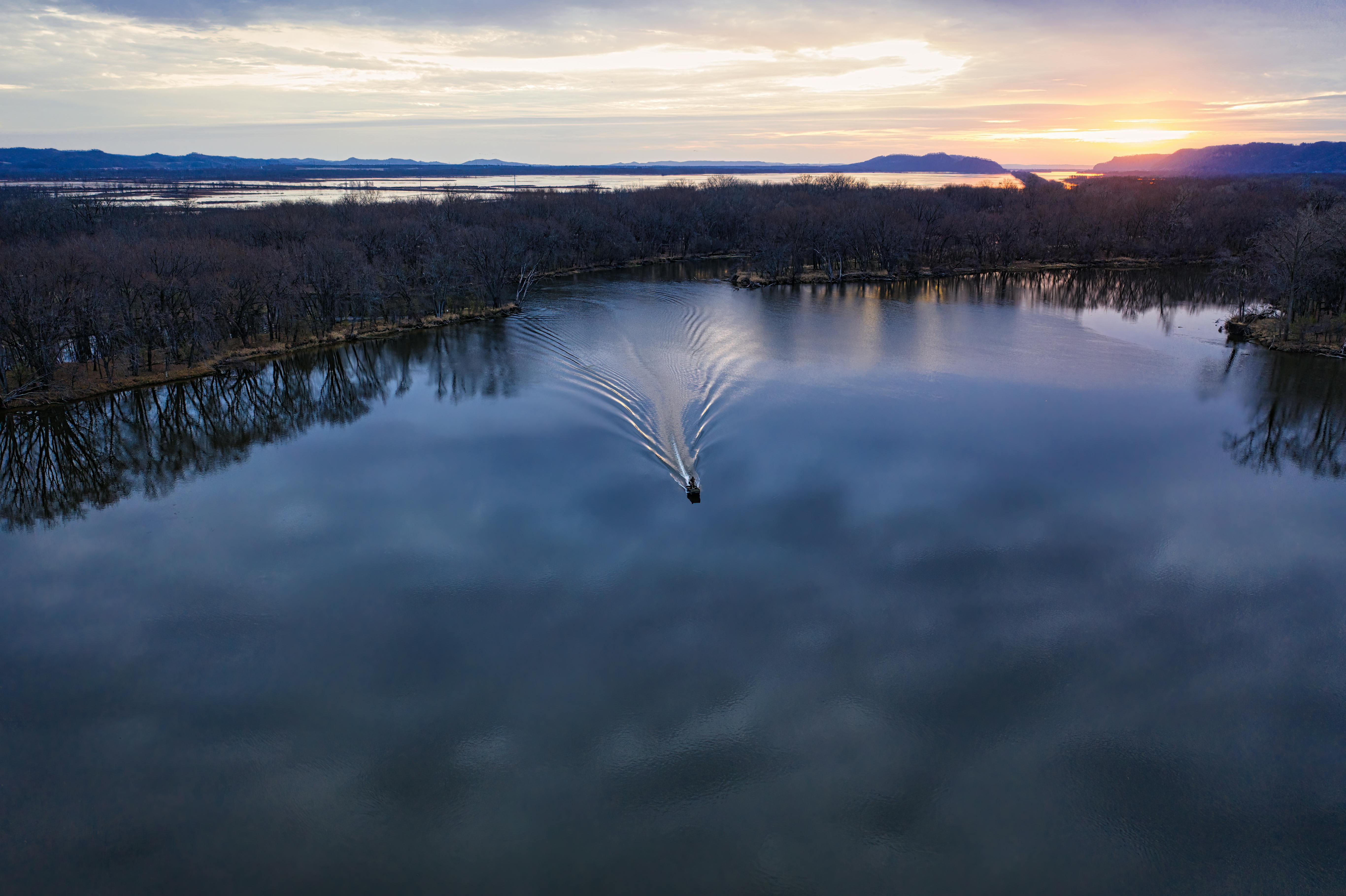 Aerial View of a Boat Sailing on a River at Sunset · Free Stock Photo