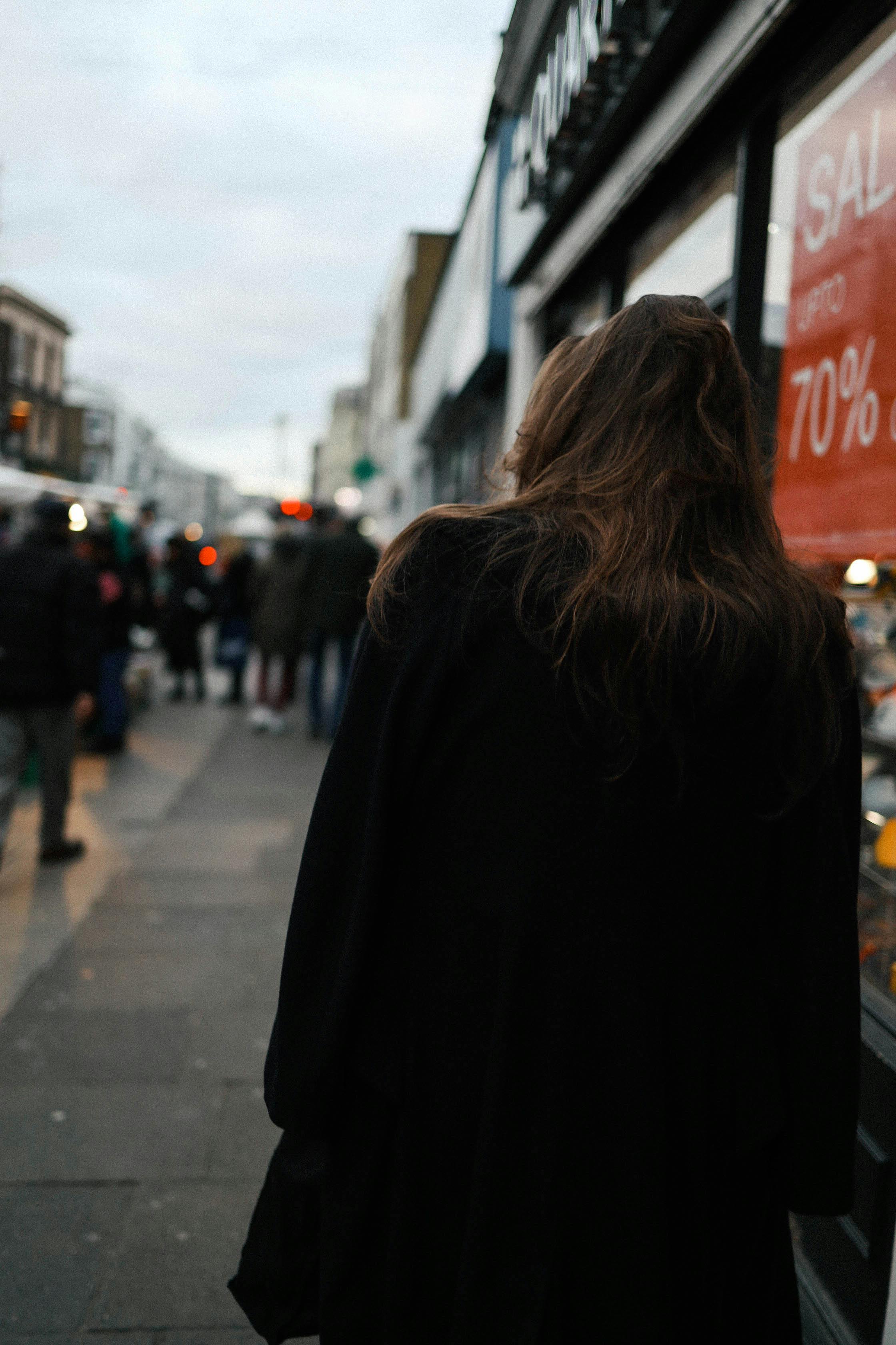 Back View of a Woman Walking Near Buildings · Free Stock Photo