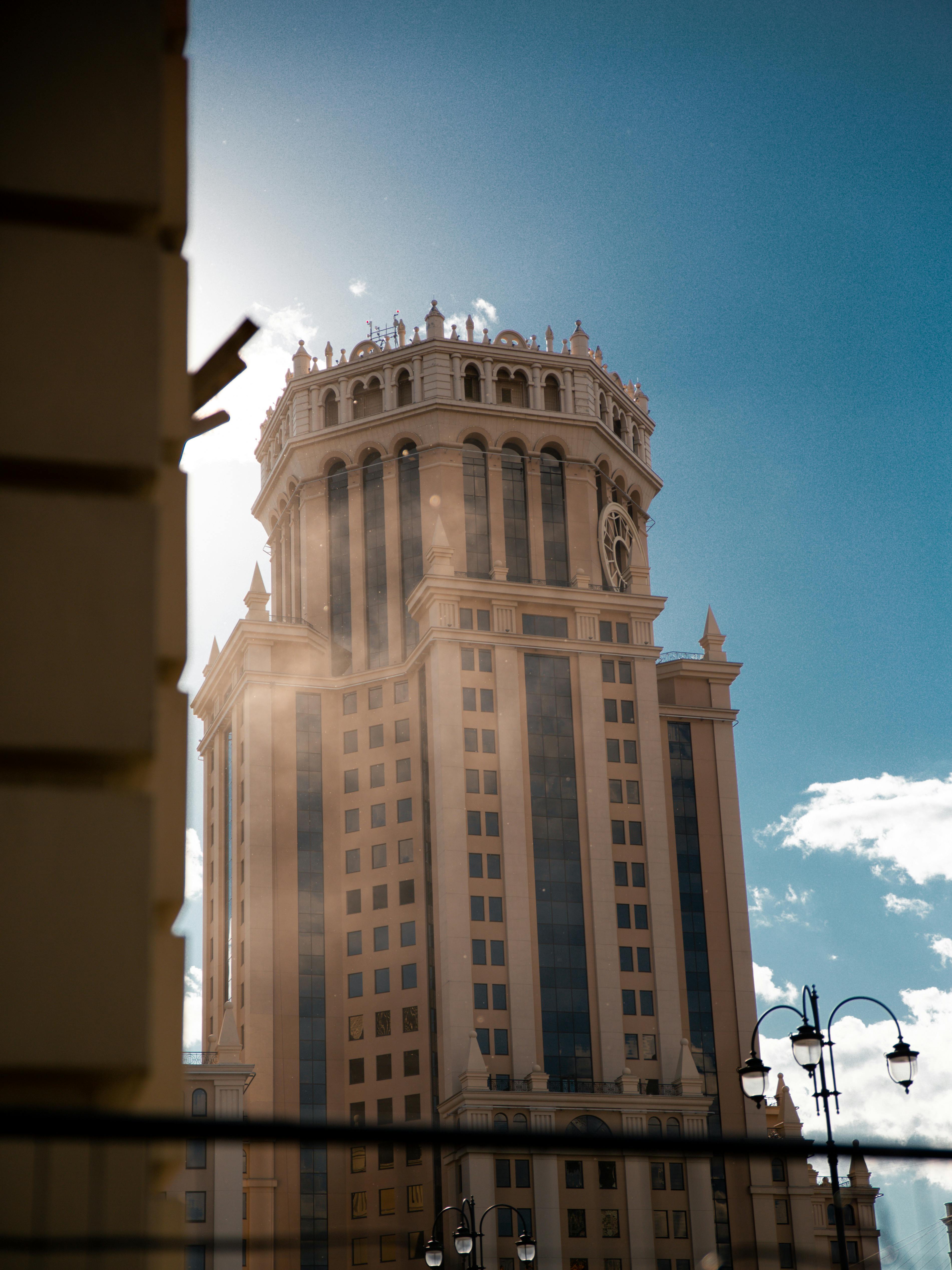 Brown Concrete Tower Near High Rise Buildings · Free Stock Photo