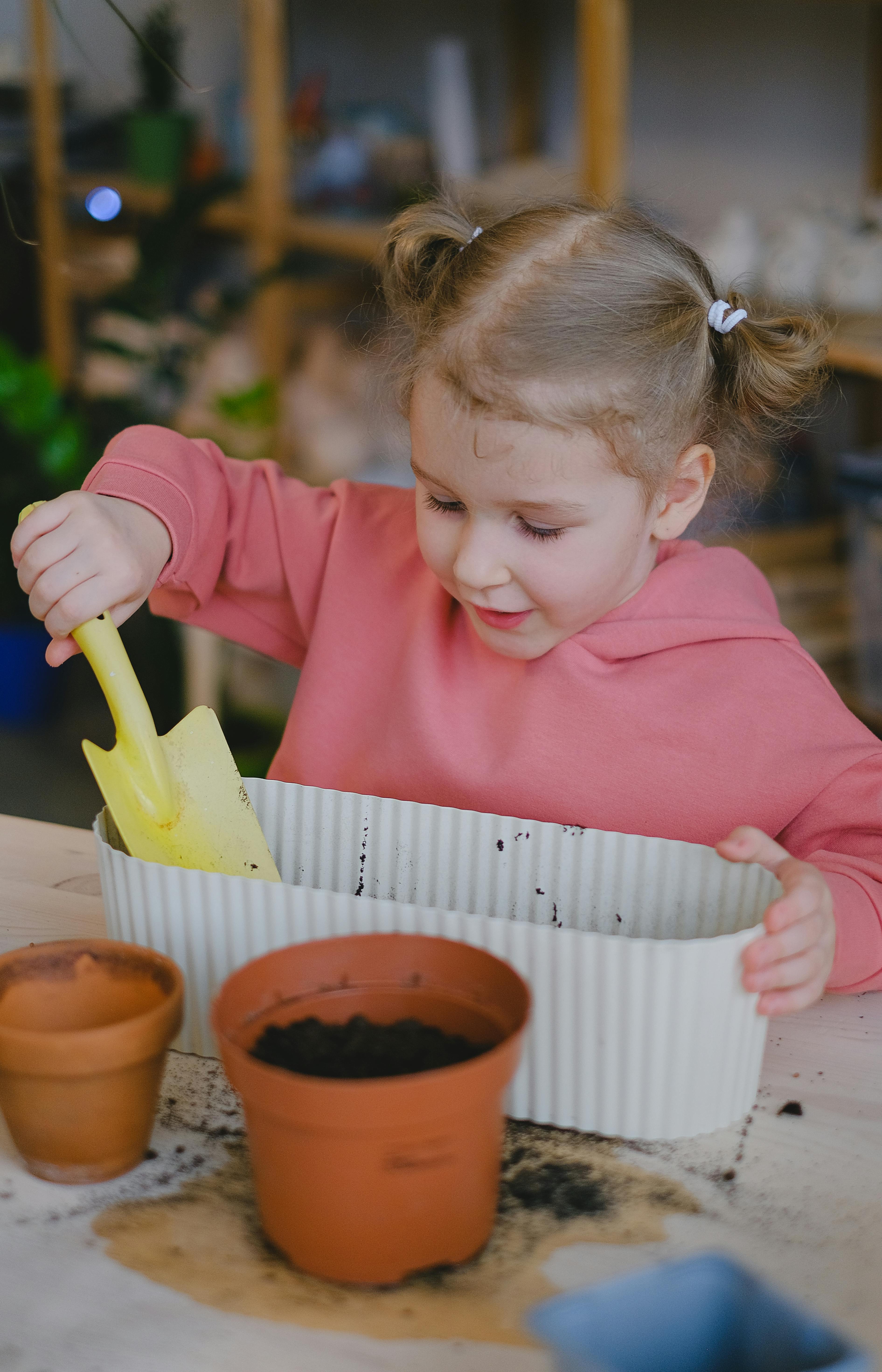 Girl Scooping Soil Using a Shovel · Free Stock Photo