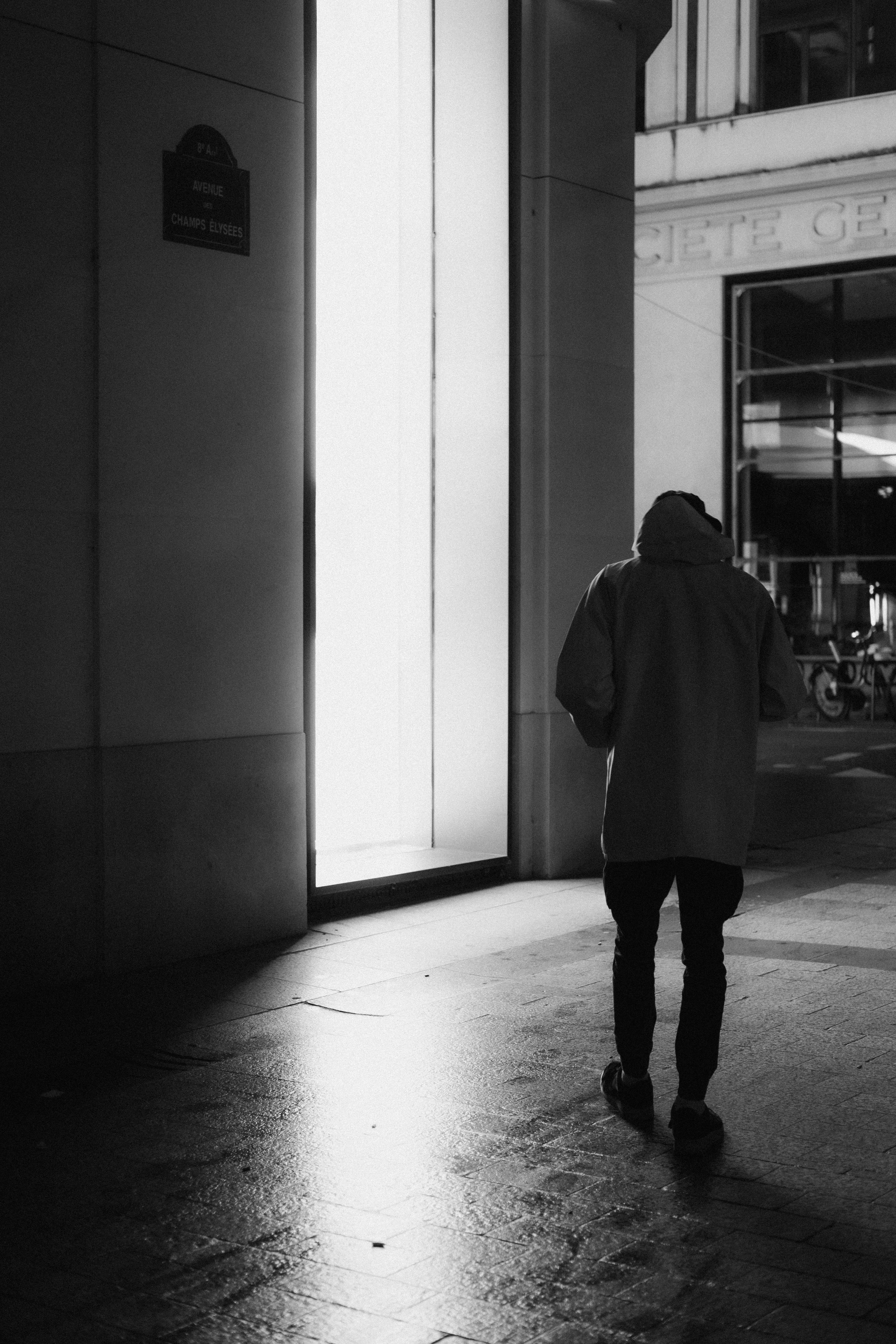 A Grayscale of a Man Walking Out the Building · Free Stock Photo