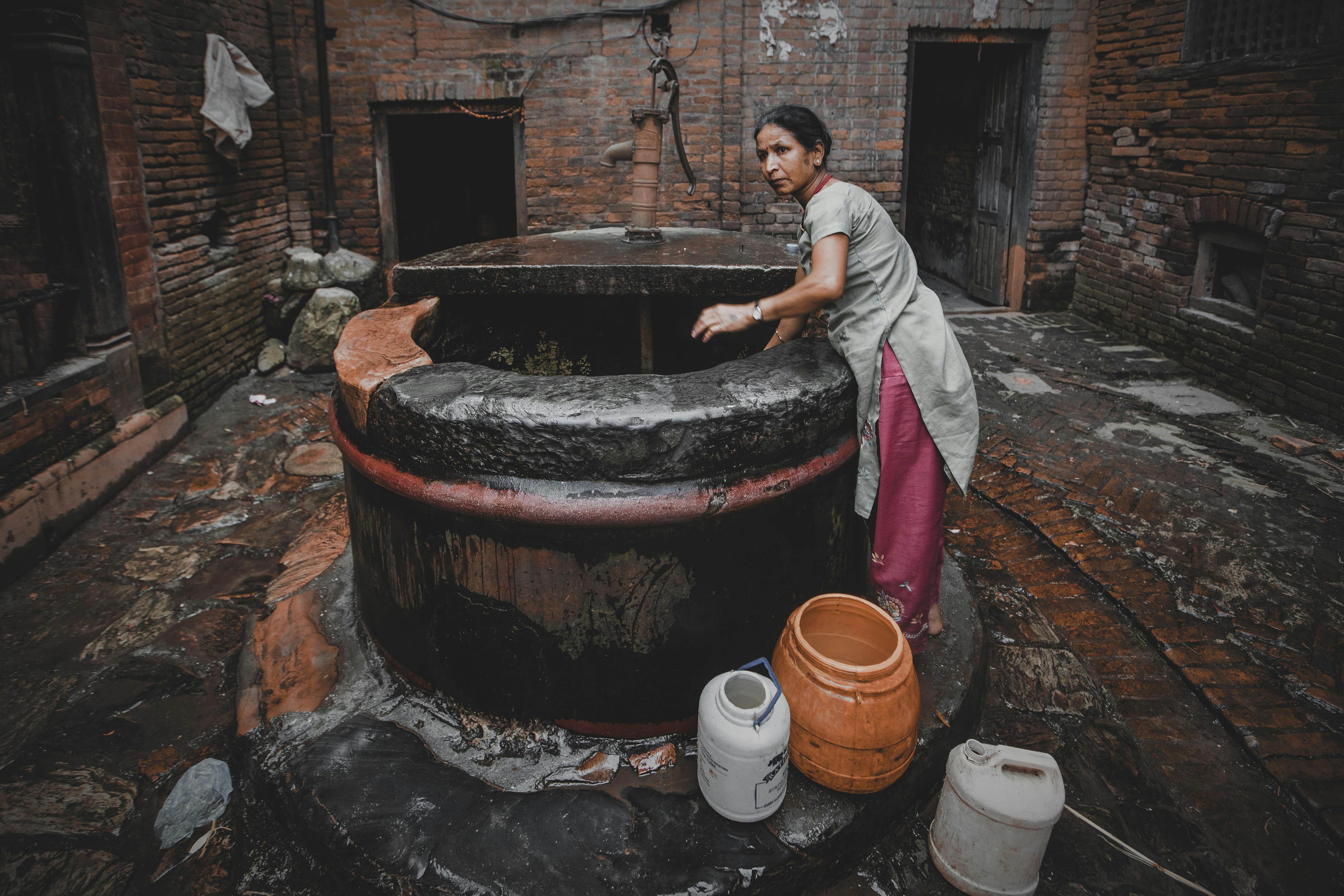 Woman Taking Water From a Well · Free Stock Photo
