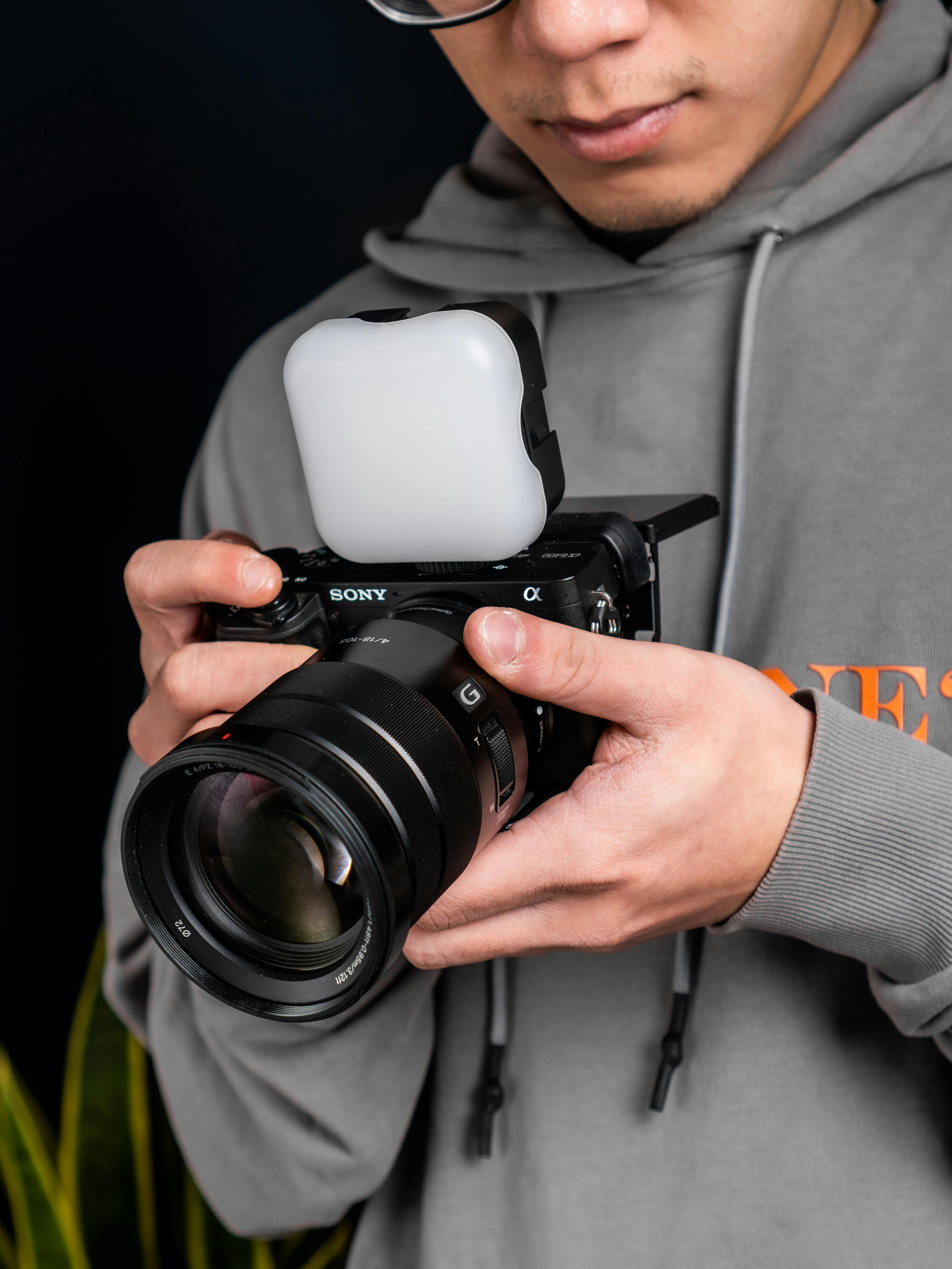 A Person in a Beige Coat Holding a Sony Camera · Free Stock Photo