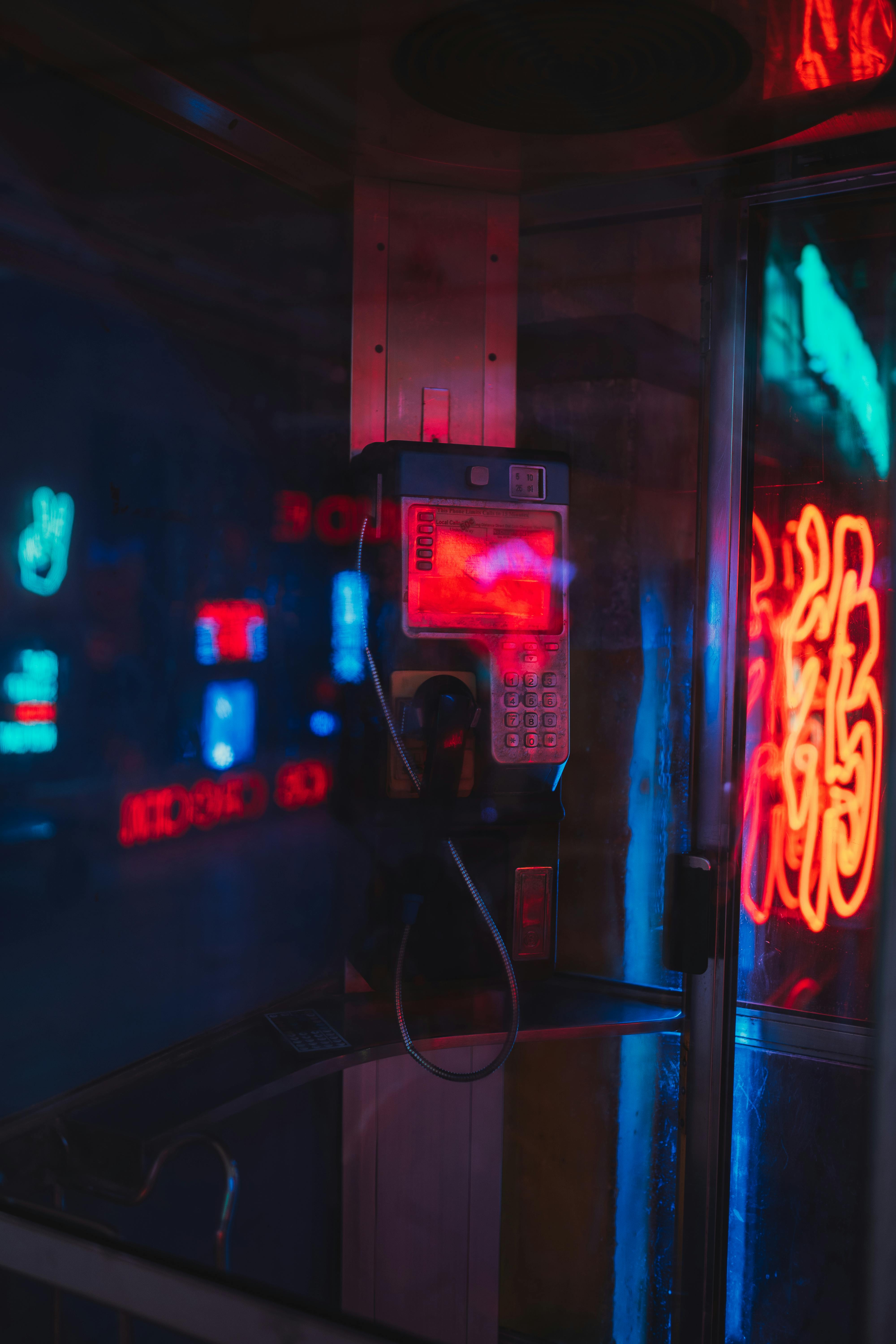A Phone Booth with Reflecting Neon Sign · Free Stock Photo
