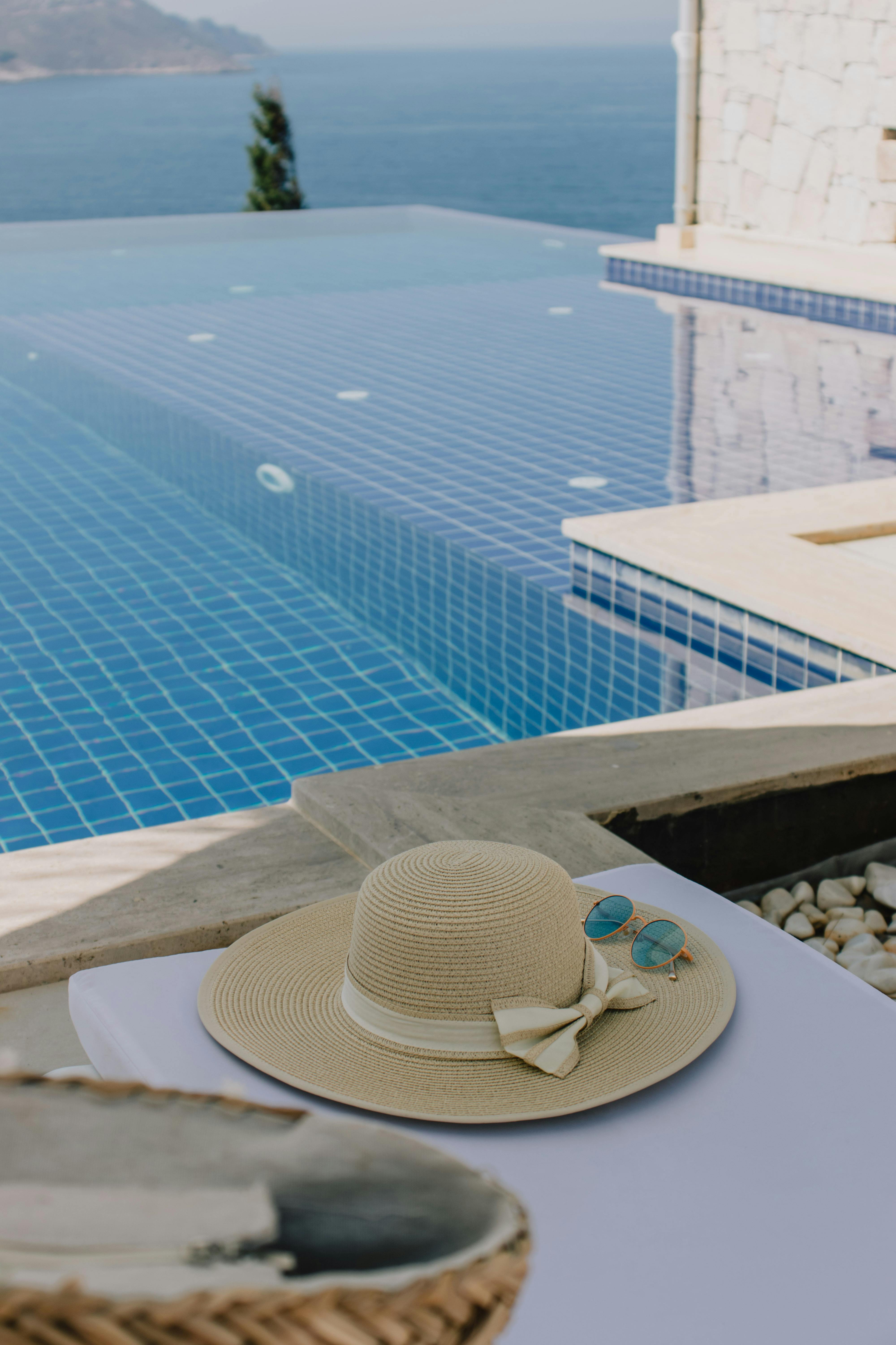Beige And Black Hat Near Swimming Pool · Free Stock Photo