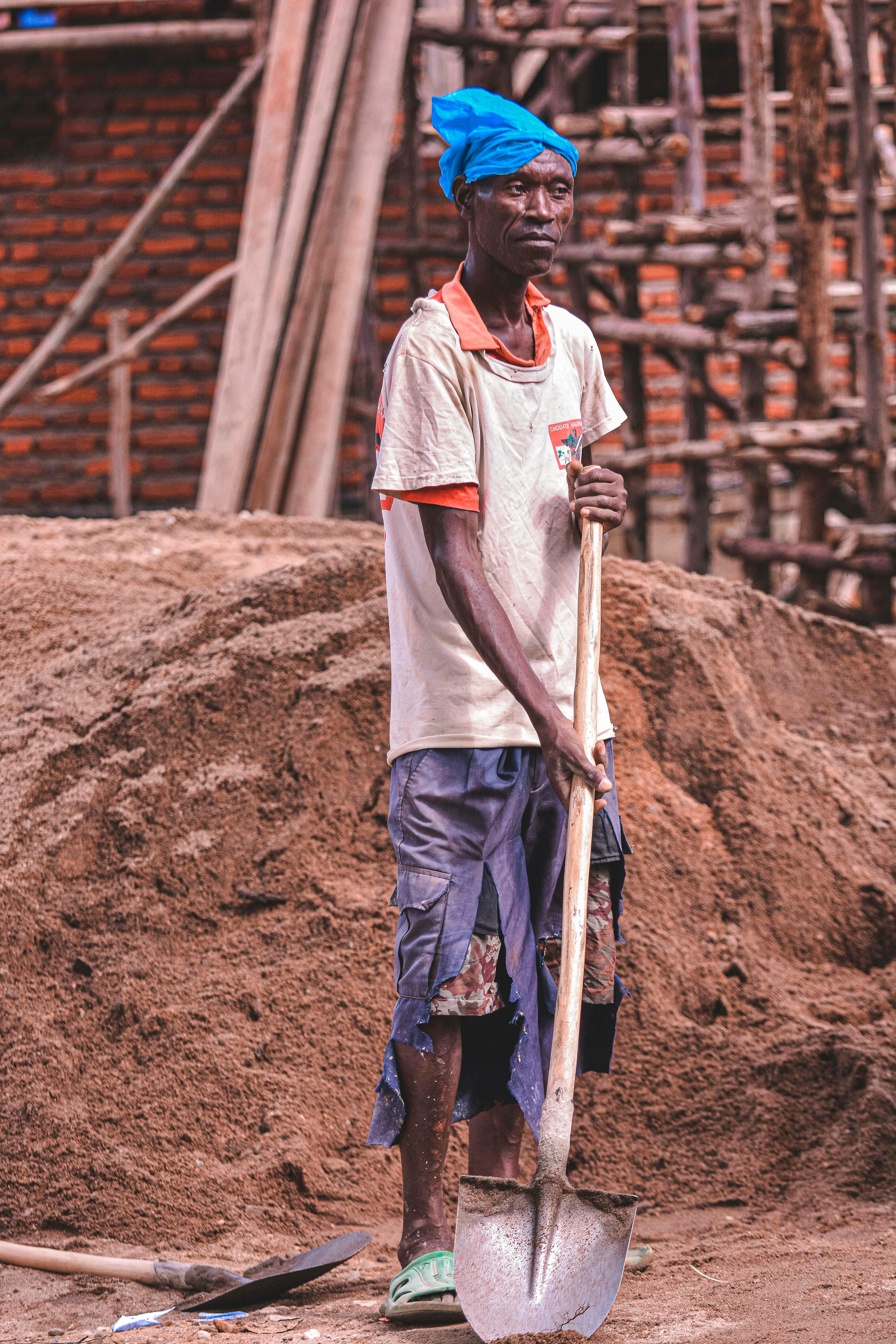 A Male Laborer Holding a Shovel · Free Stock Photo