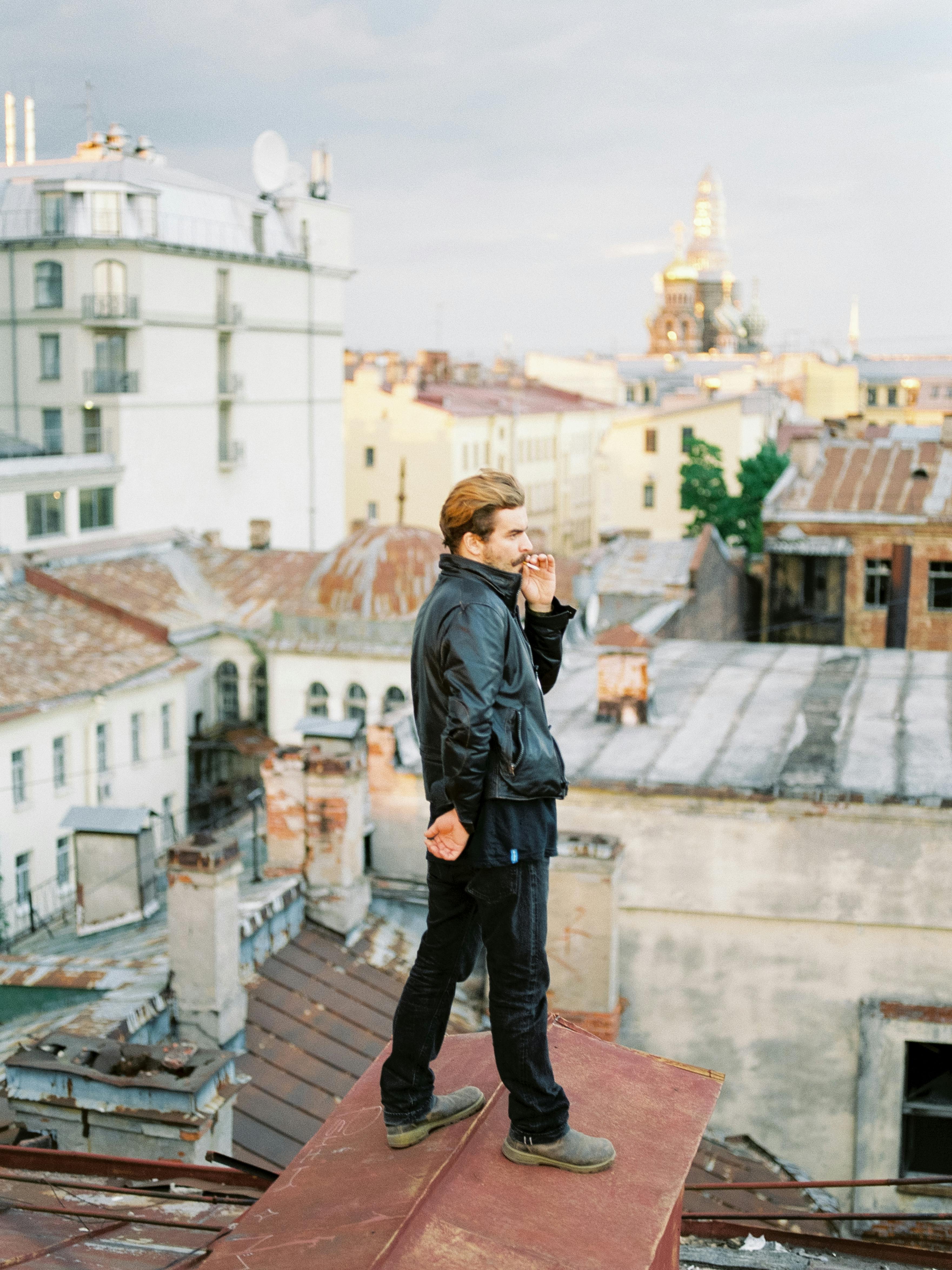Man Smoking Cigarette on Roof · Free Stock Photo
