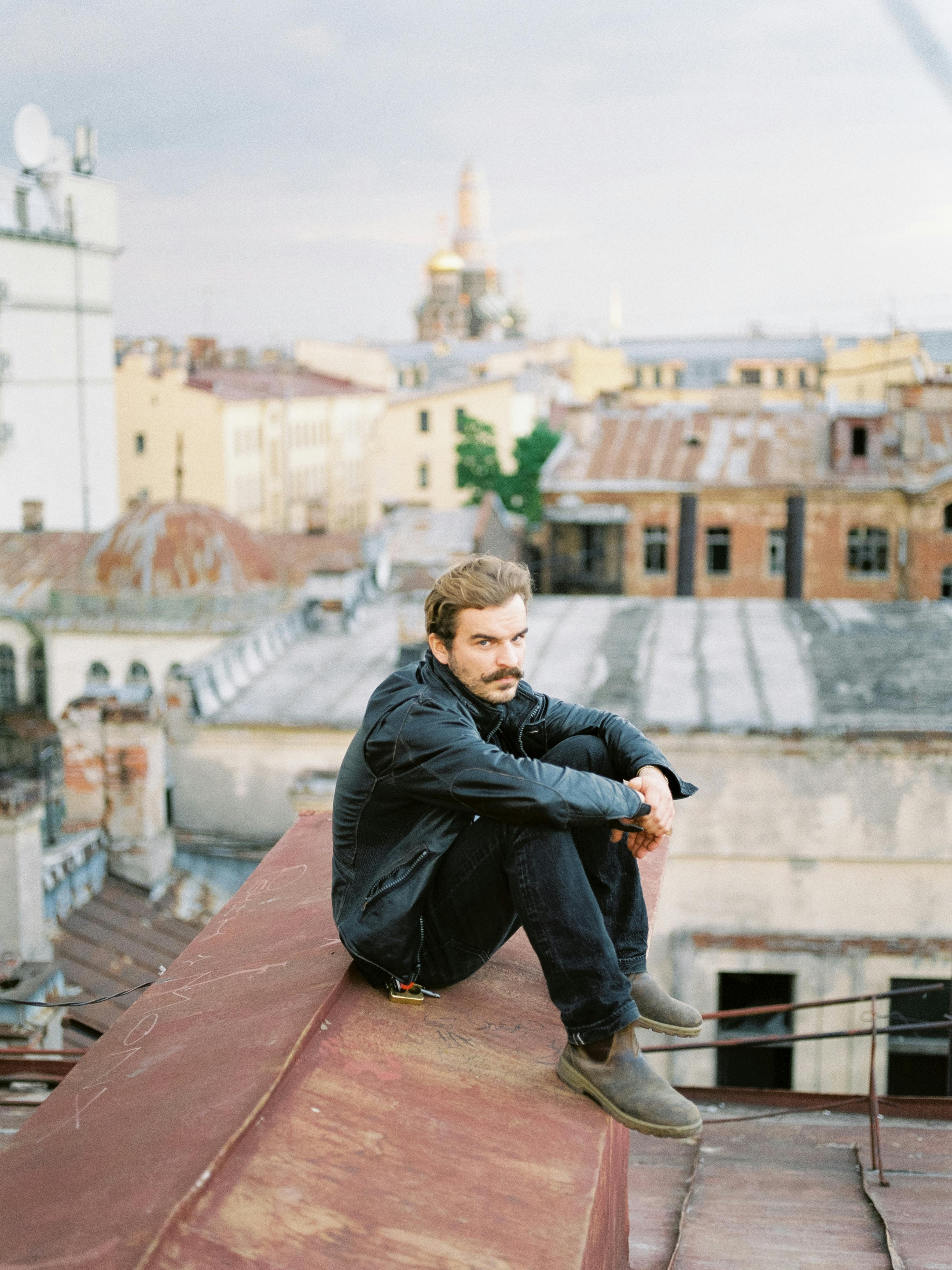 Portrait of Man Sitting on Roof · Free Stock Photo
