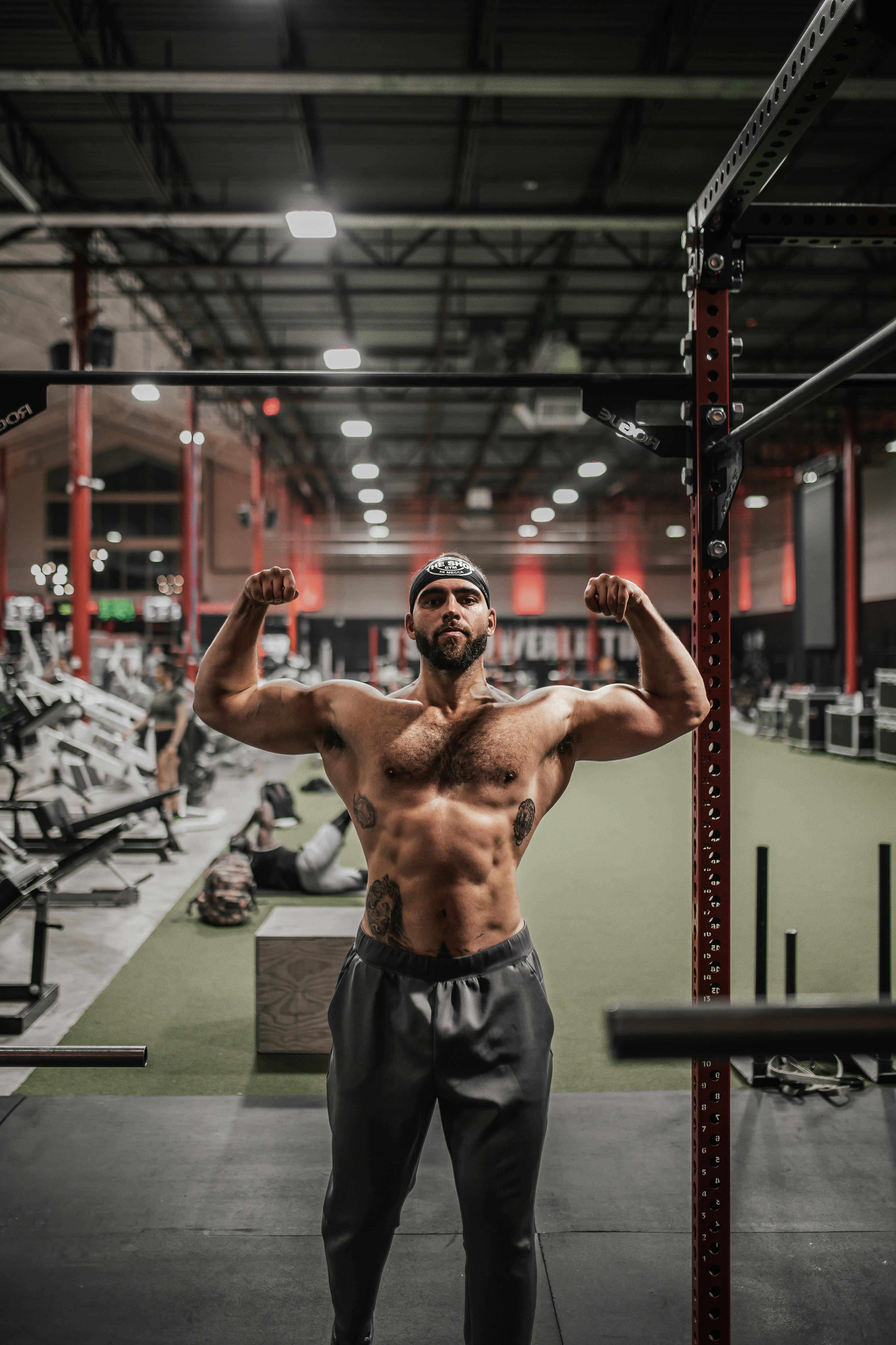 Muscular Man Putting on Protection Equipment in a Gym · Free Stock Photo
