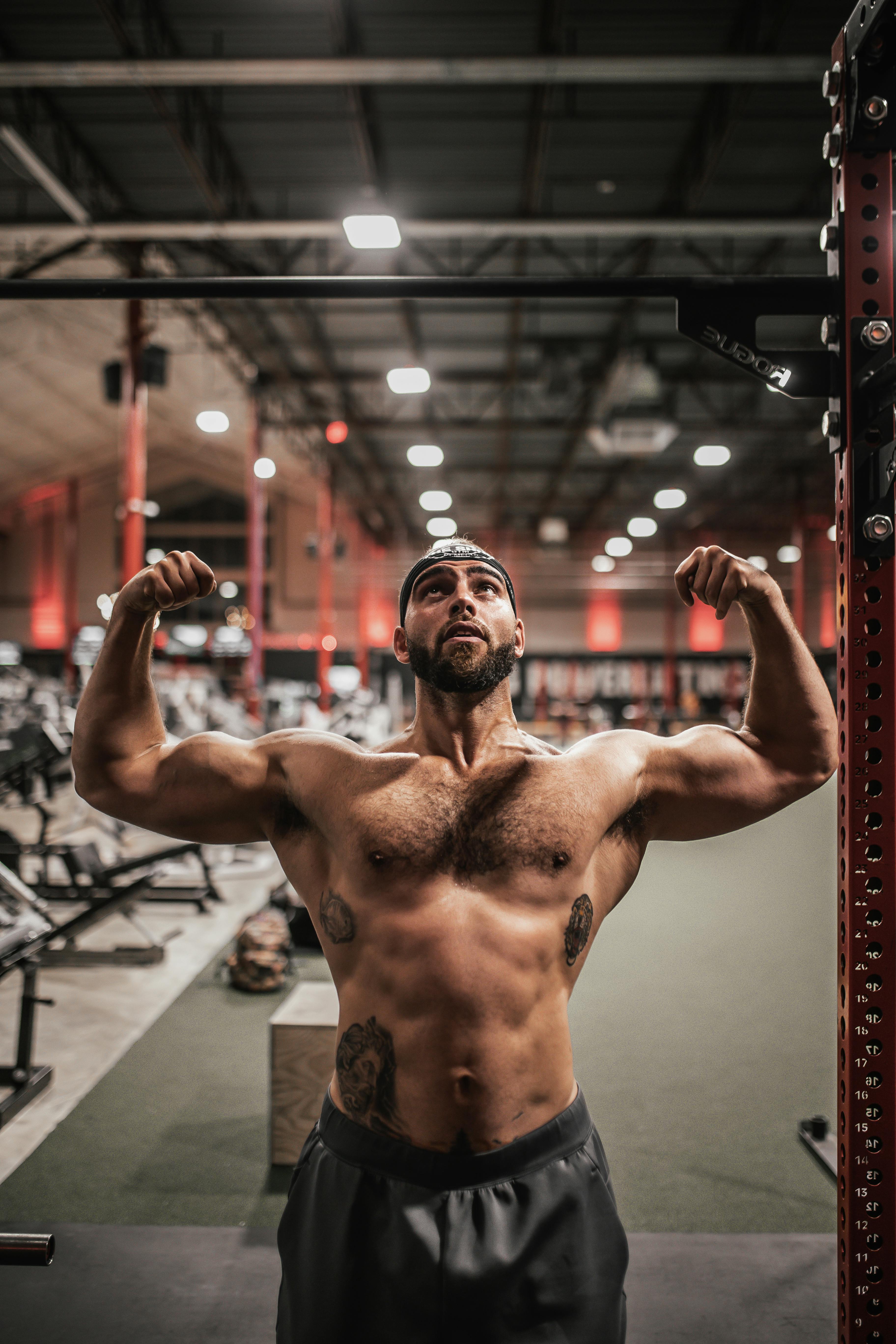 Muscular Man Putting on Protection Equipment in a Gym · Free Stock Photo