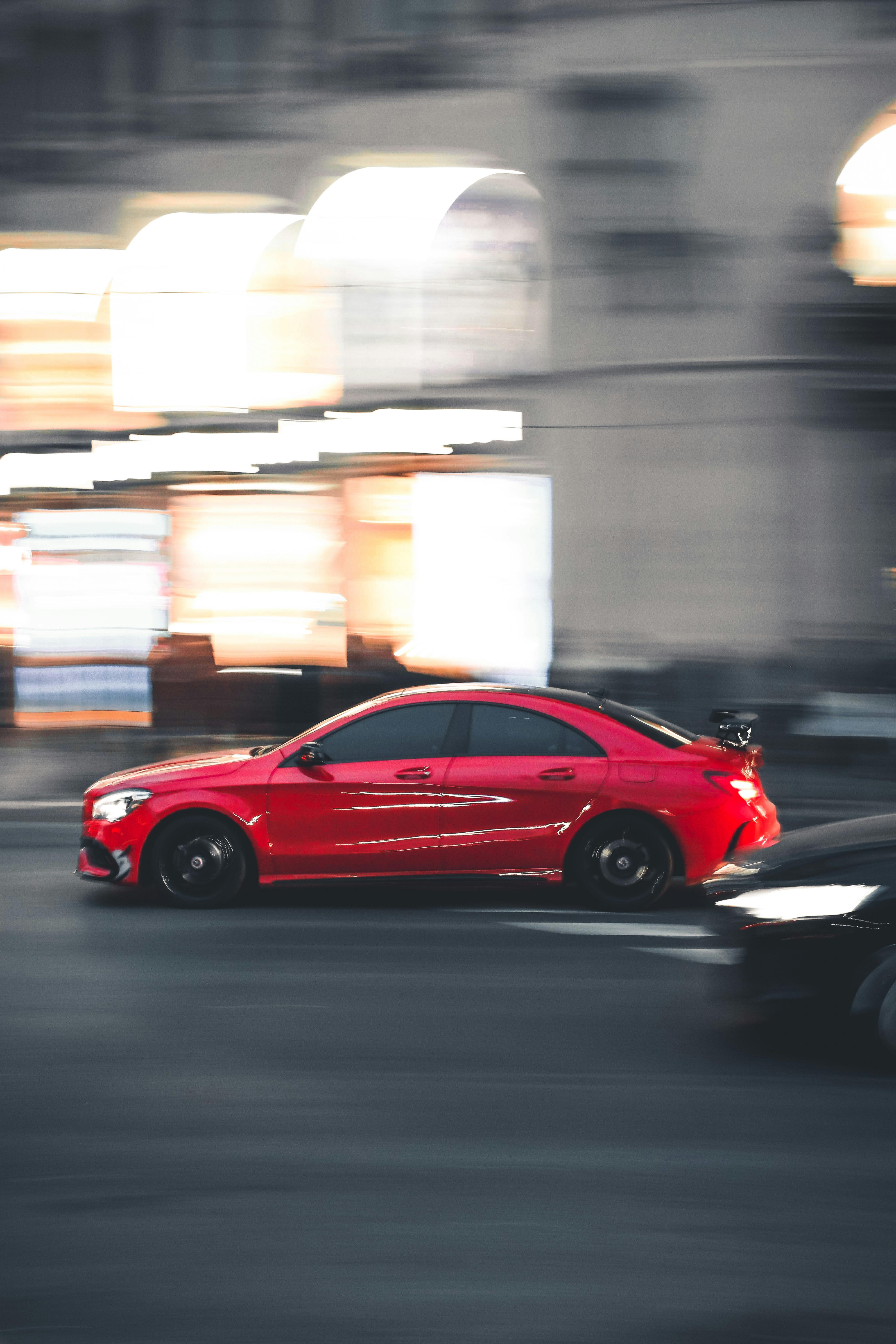 Blurred Image of a Red Car Driving Fast in a City · Free Stock Photo