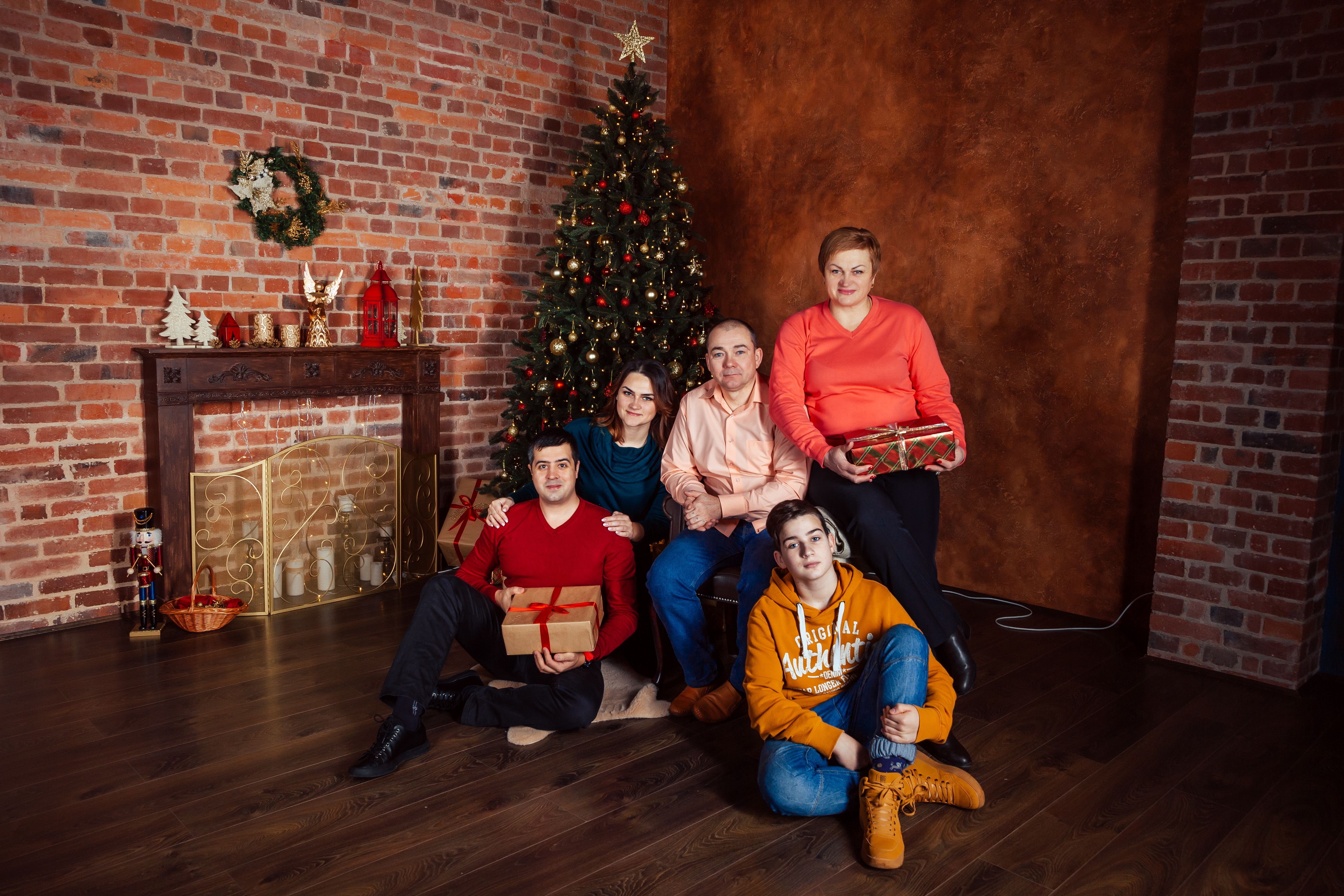 A Group of People Sitting Beside a Christmas Tree During Christmas ...