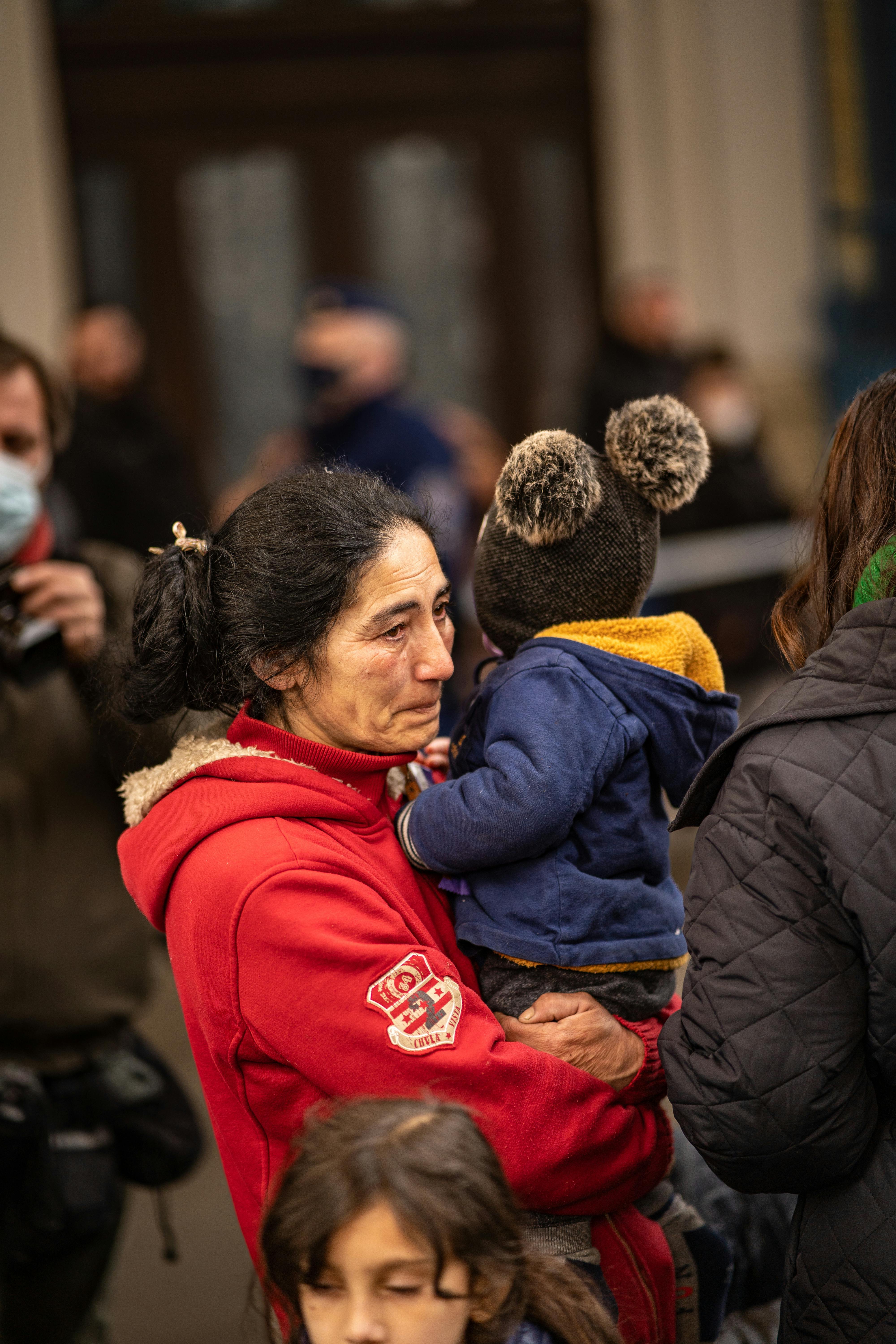 Distressed Mother carrying her Child · Free Stock Photo