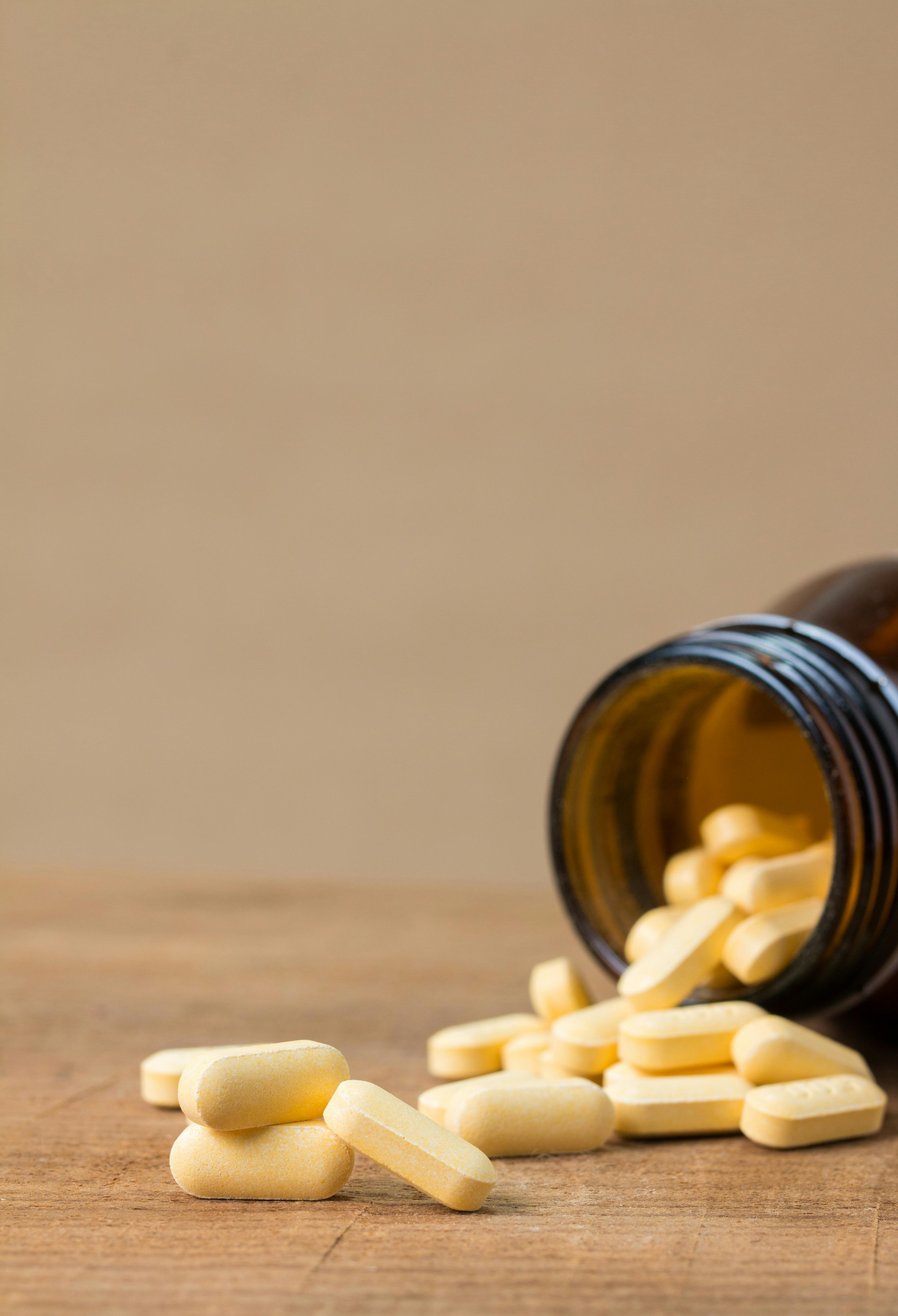 Yellow Medication Pills on Gray Surface · Free Stock Photo