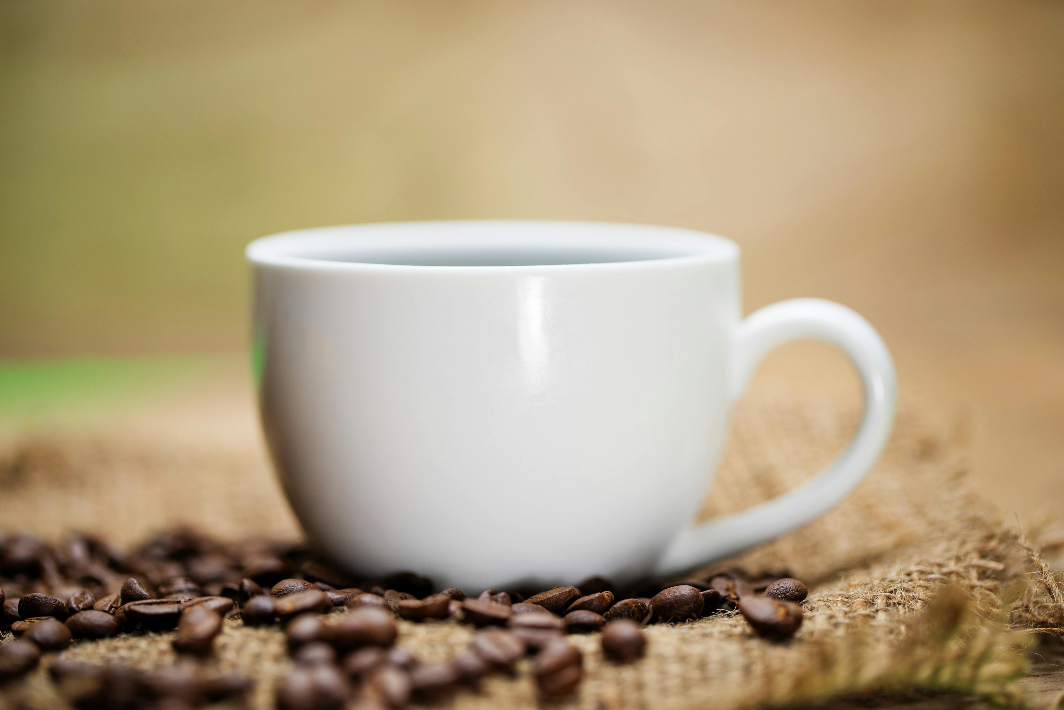 Steaming Cup of Coffee with Coffee Beans · Free Stock Photo