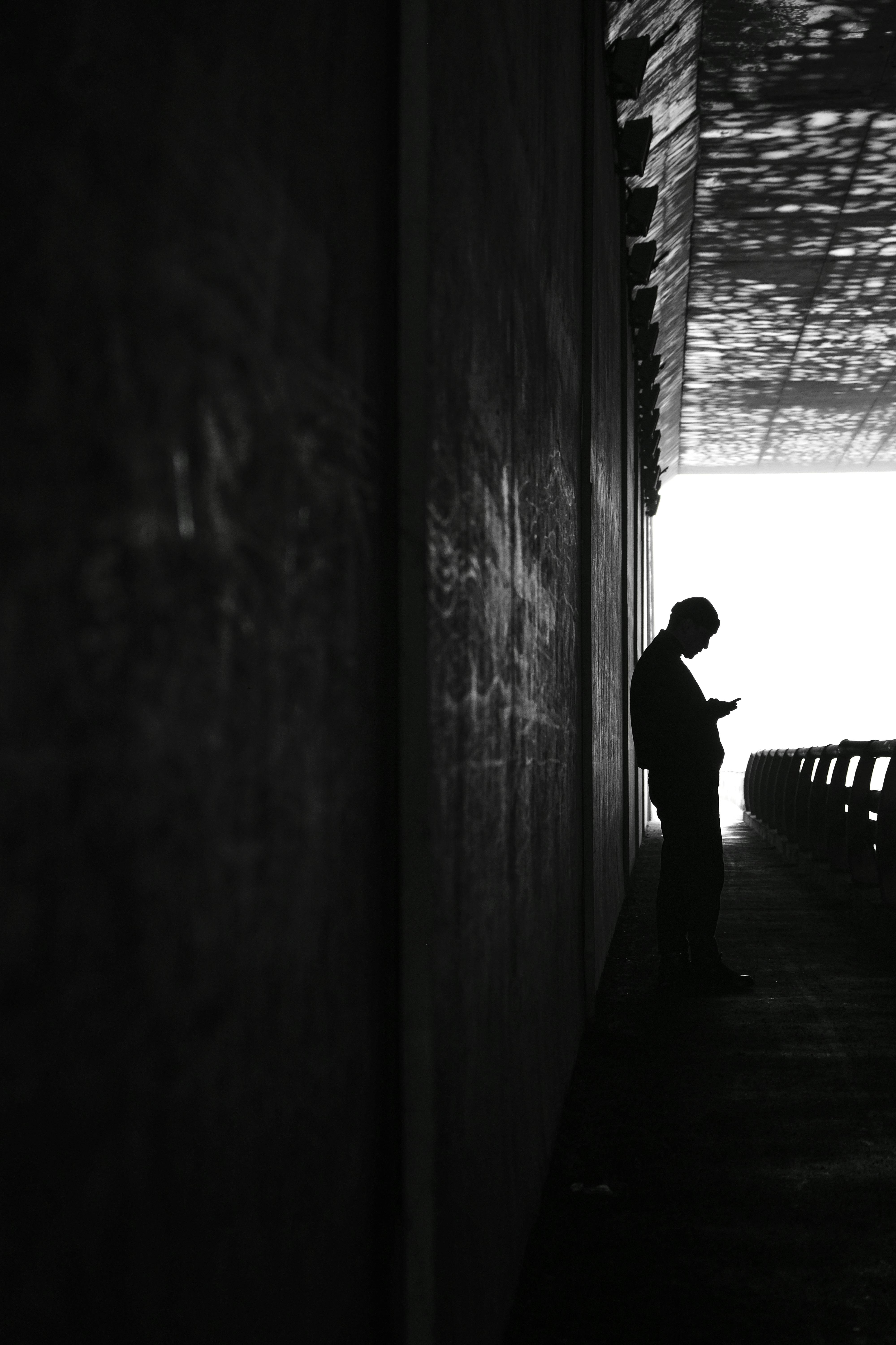 Man Standing in Shadow under Pipe on Wall · Free Stock Photo