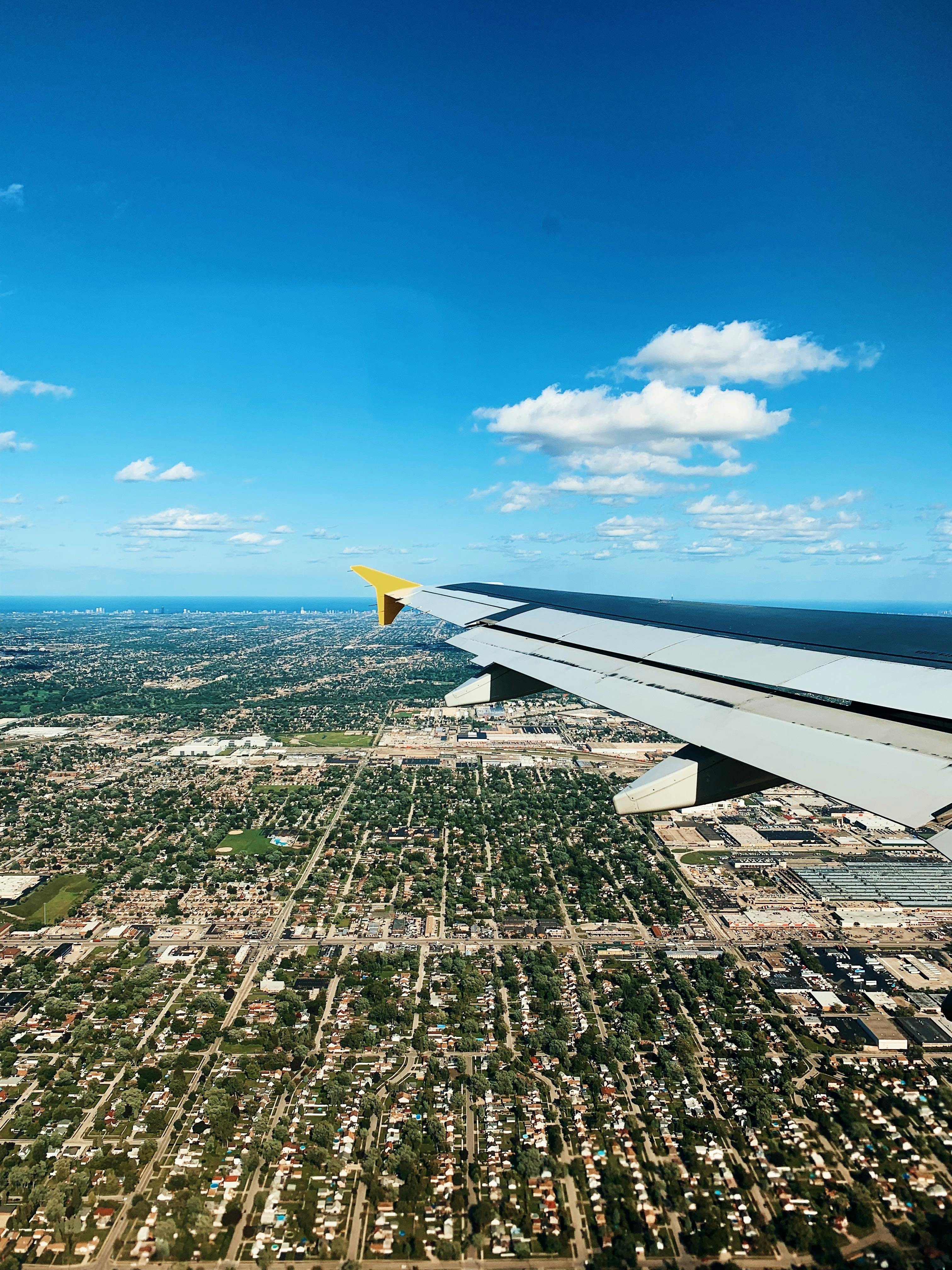 Wing of Airplane Flying over Town · Free Stock Photo